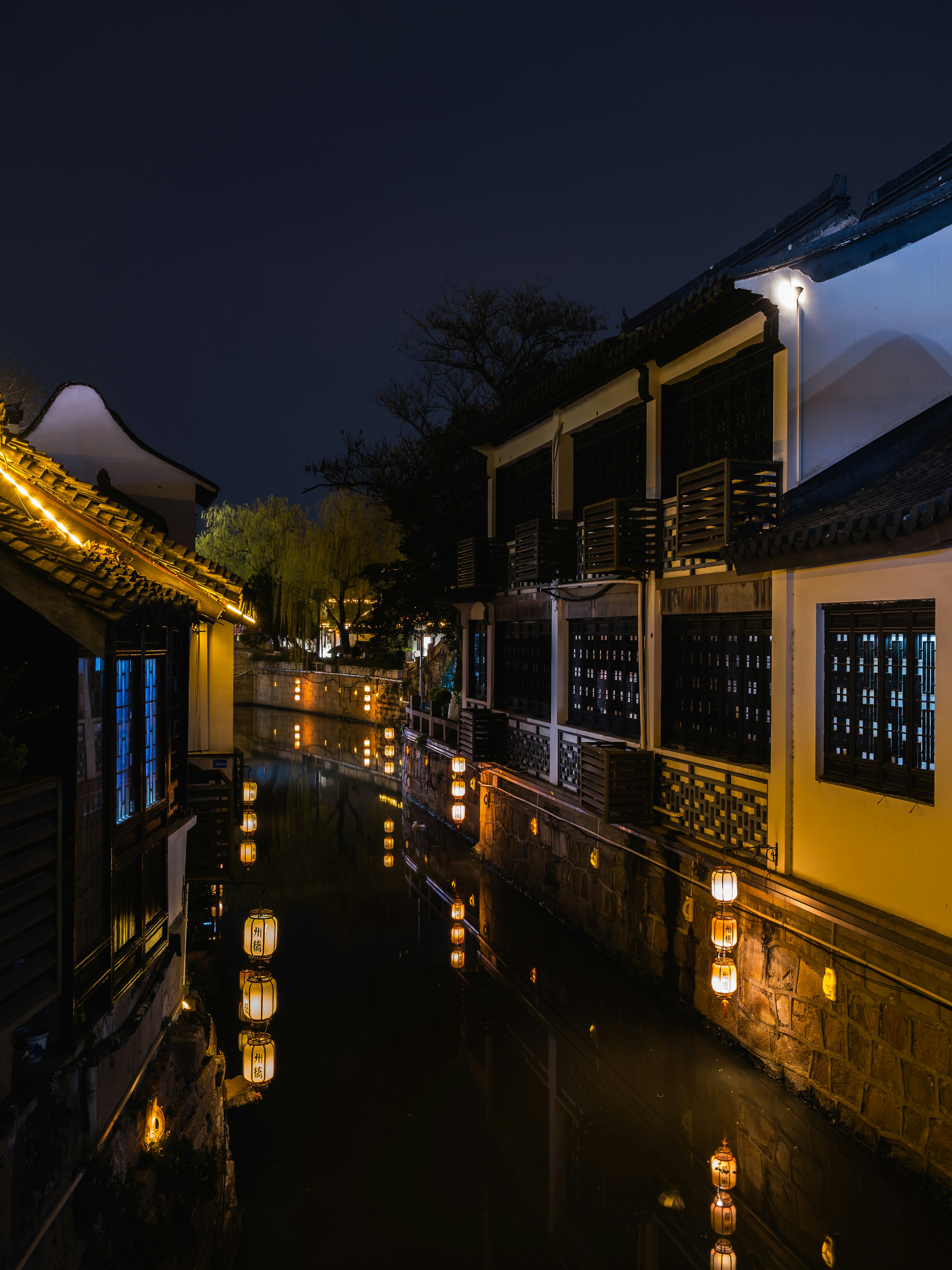 Lantern-lit Canal Alley Between Traditional Rooftops at Night