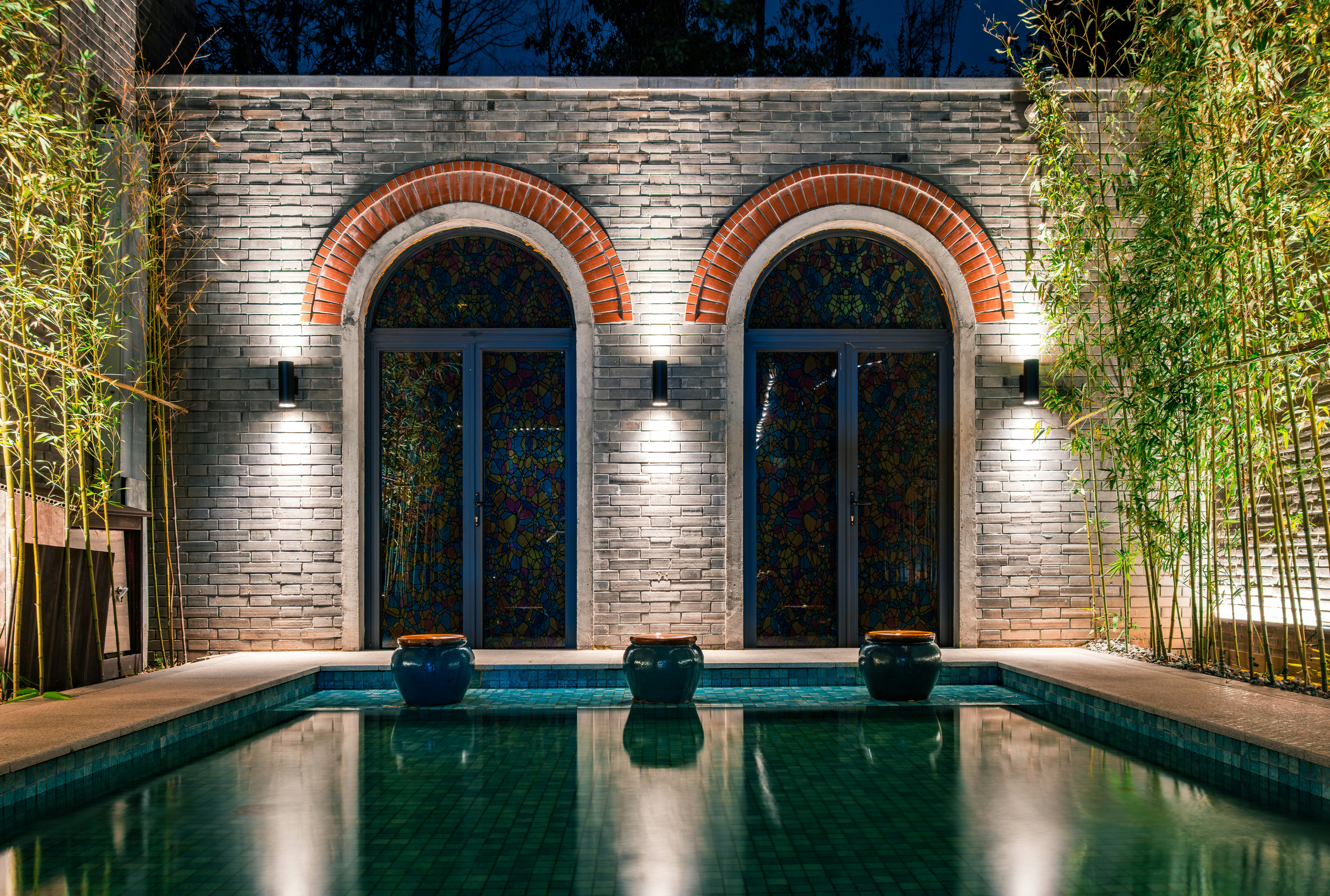 Symmetrical Night Oasis: Archways, Water, and Lantern Light