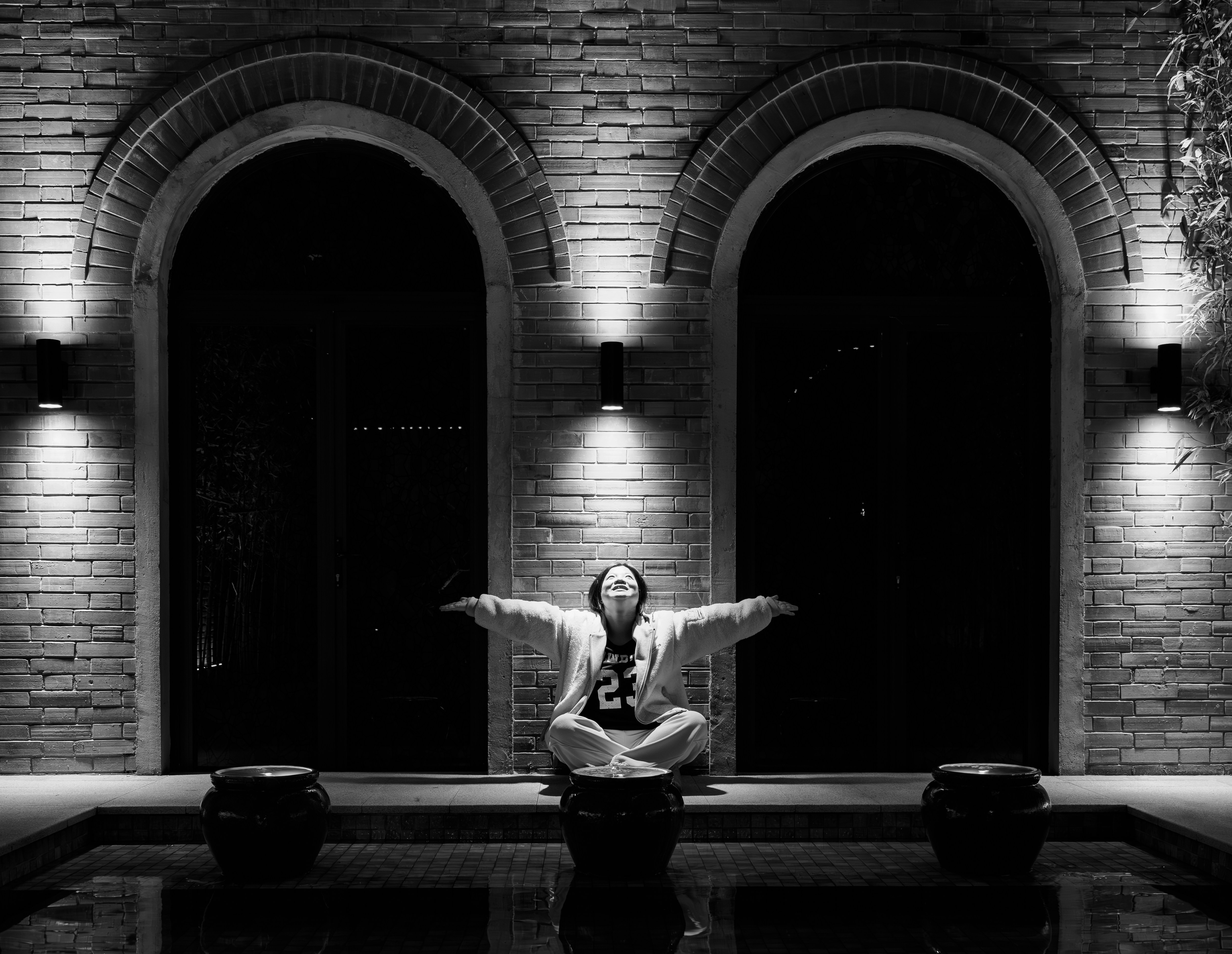 Hands Wide, Heart Open: Night Oasis of Brick and Water