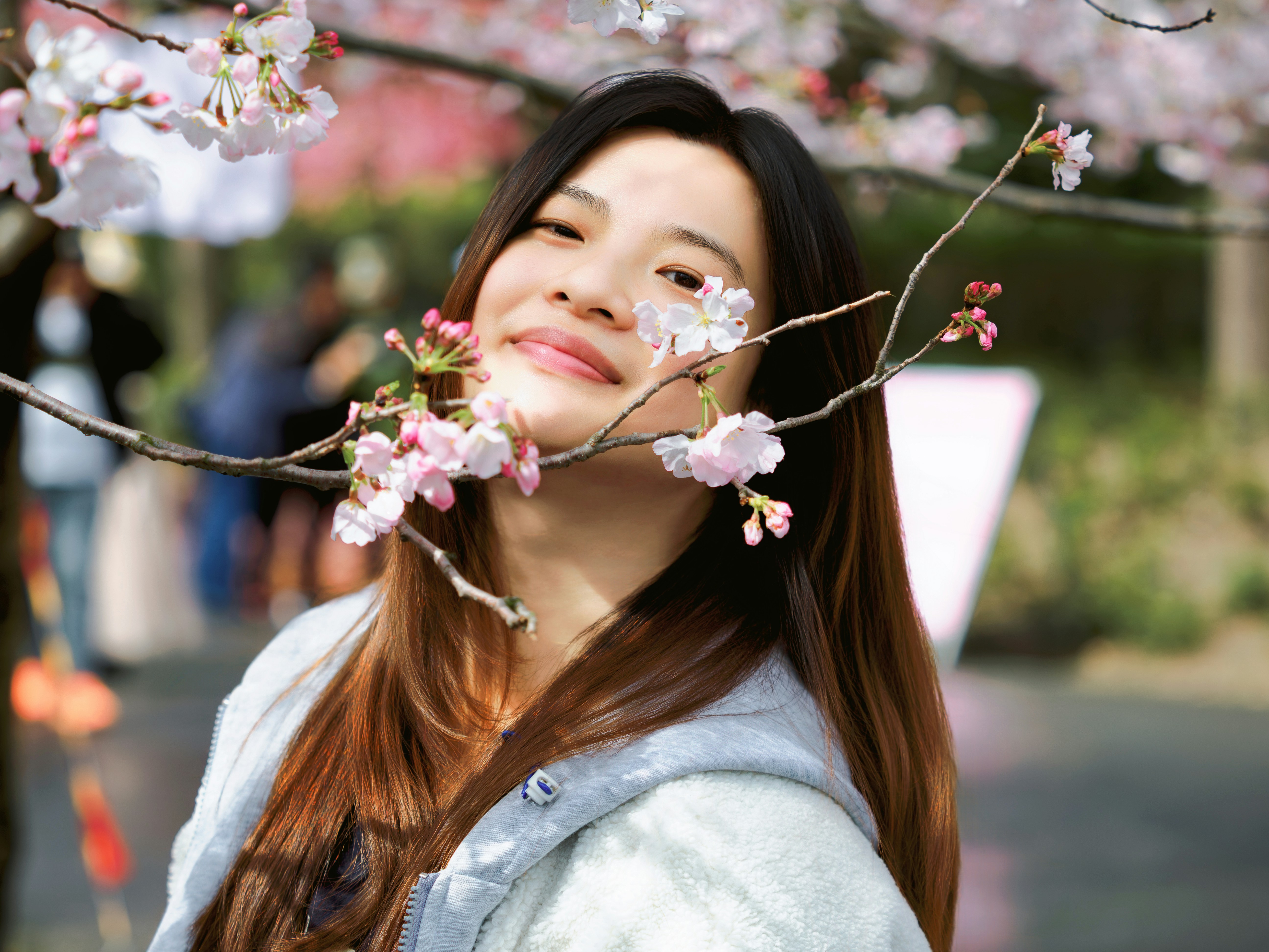 Blossoms and a Warm Smile: Portrait Beneath Pink Petals