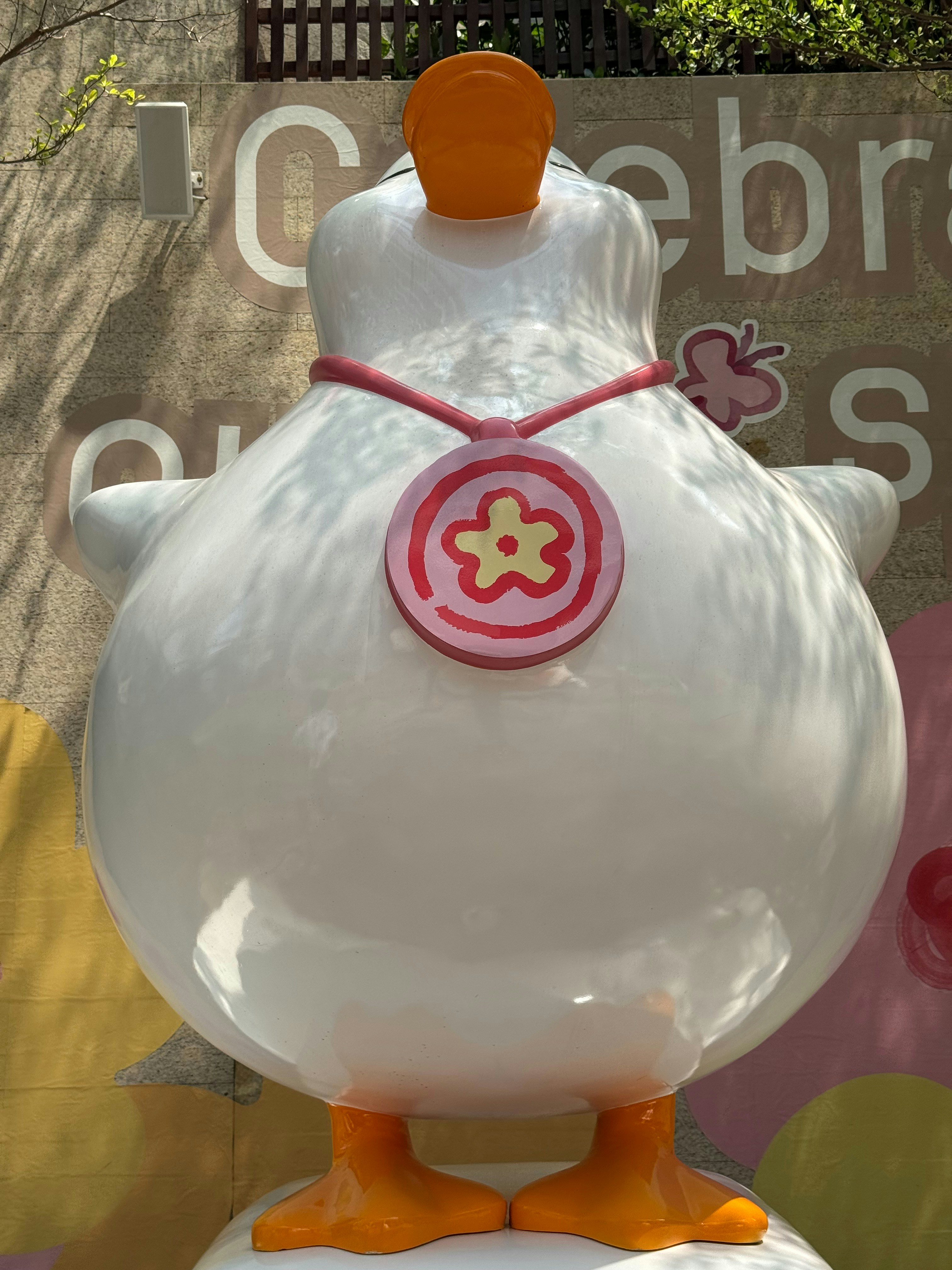 Stitched Sun-Top Chick: A Rotund Chicken Character in Front of a Colorful Backdrop