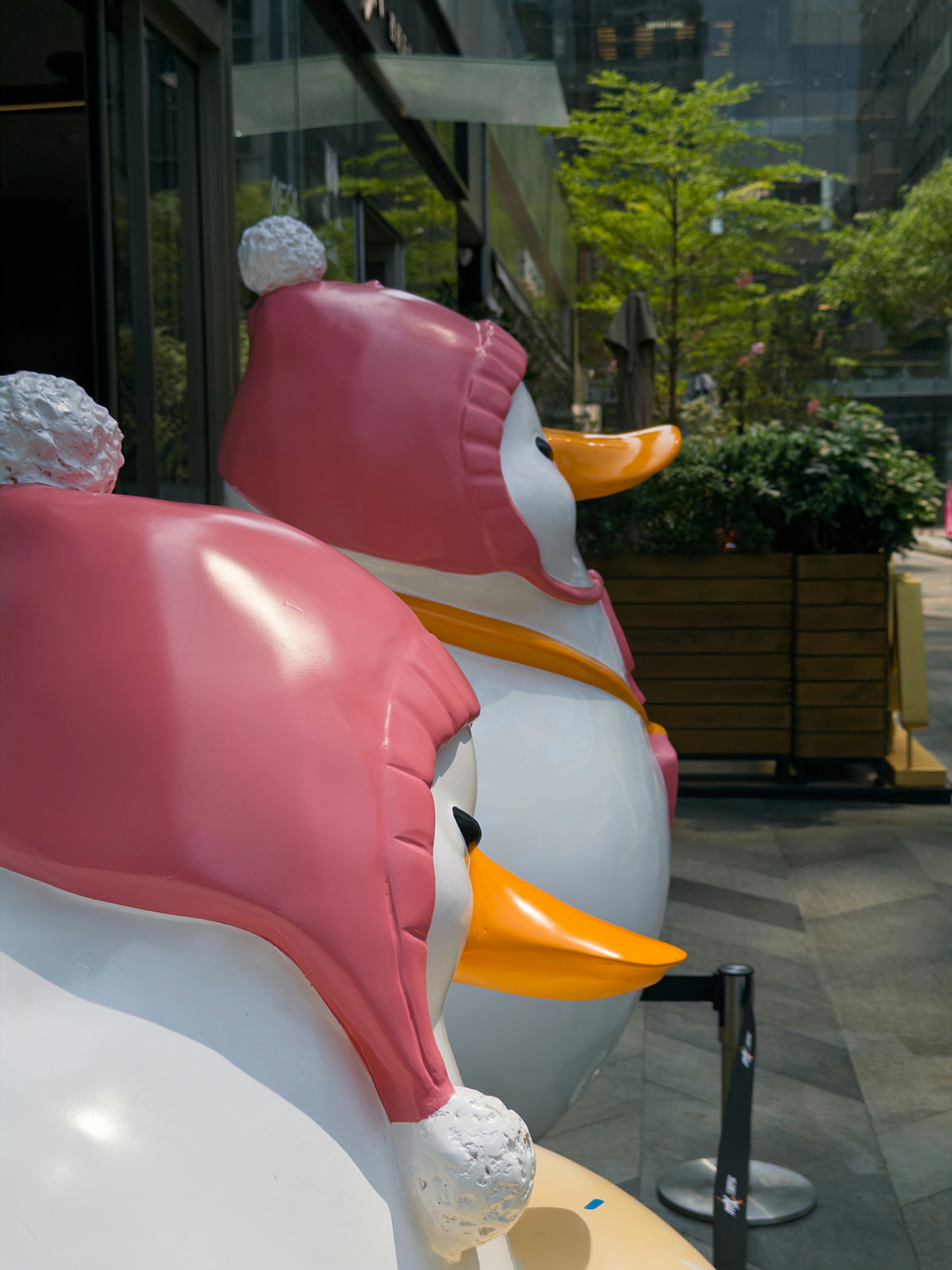 Giant pink penguins in an urban courtyard
