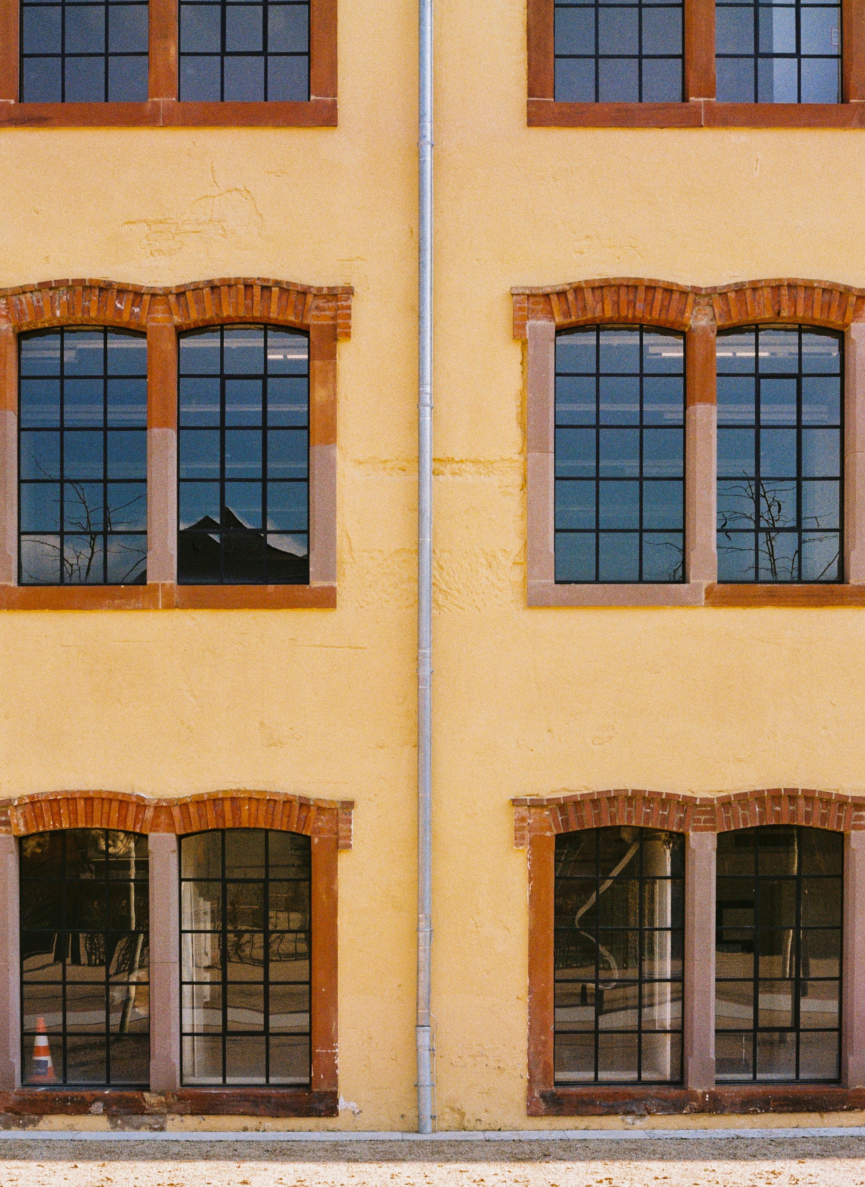 Symmetry Between Walls: A Yellow Façade Split by a Silver Vein