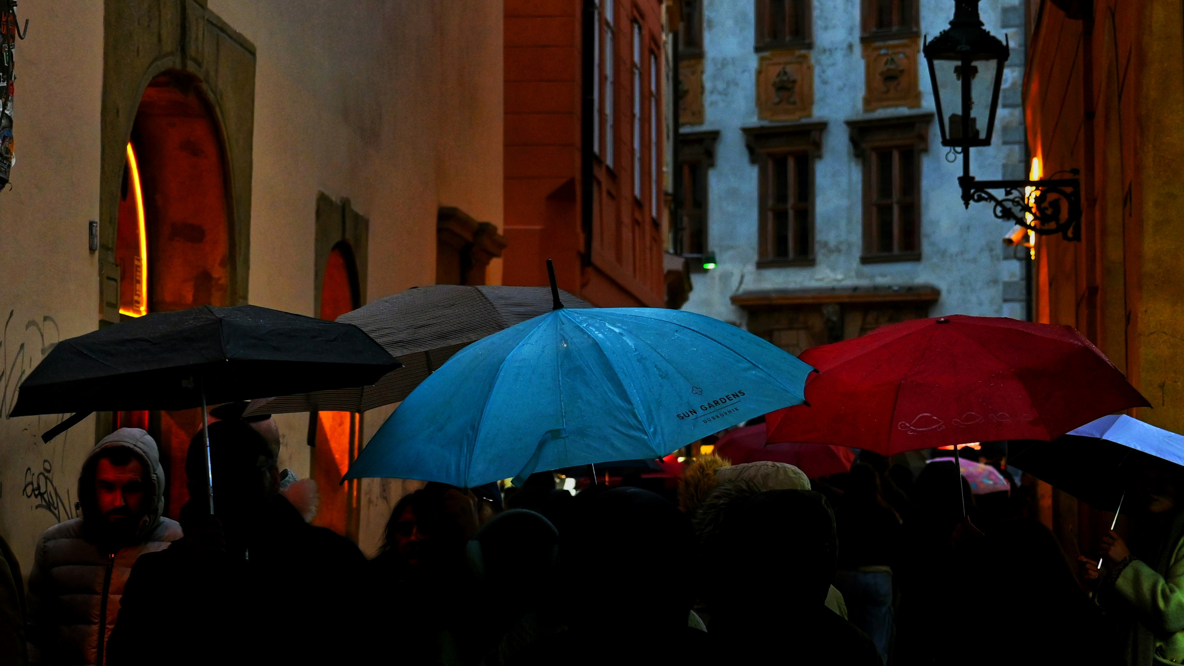 Blue Umbrella Amid the Lantern-lit Alleyway Crowd