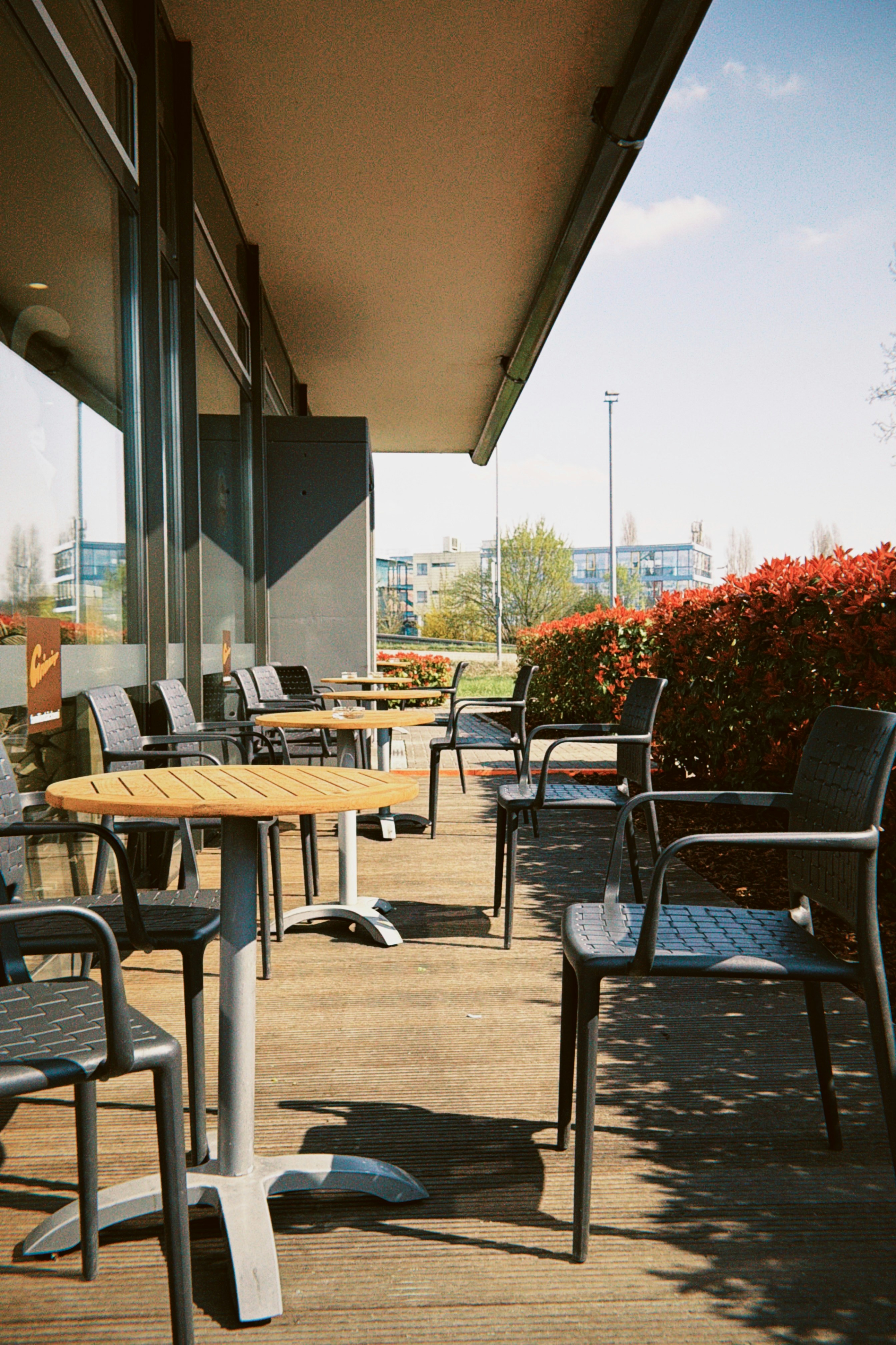 Quiet Terrace in the Sun: Empty Tables and Shadowed Walkway