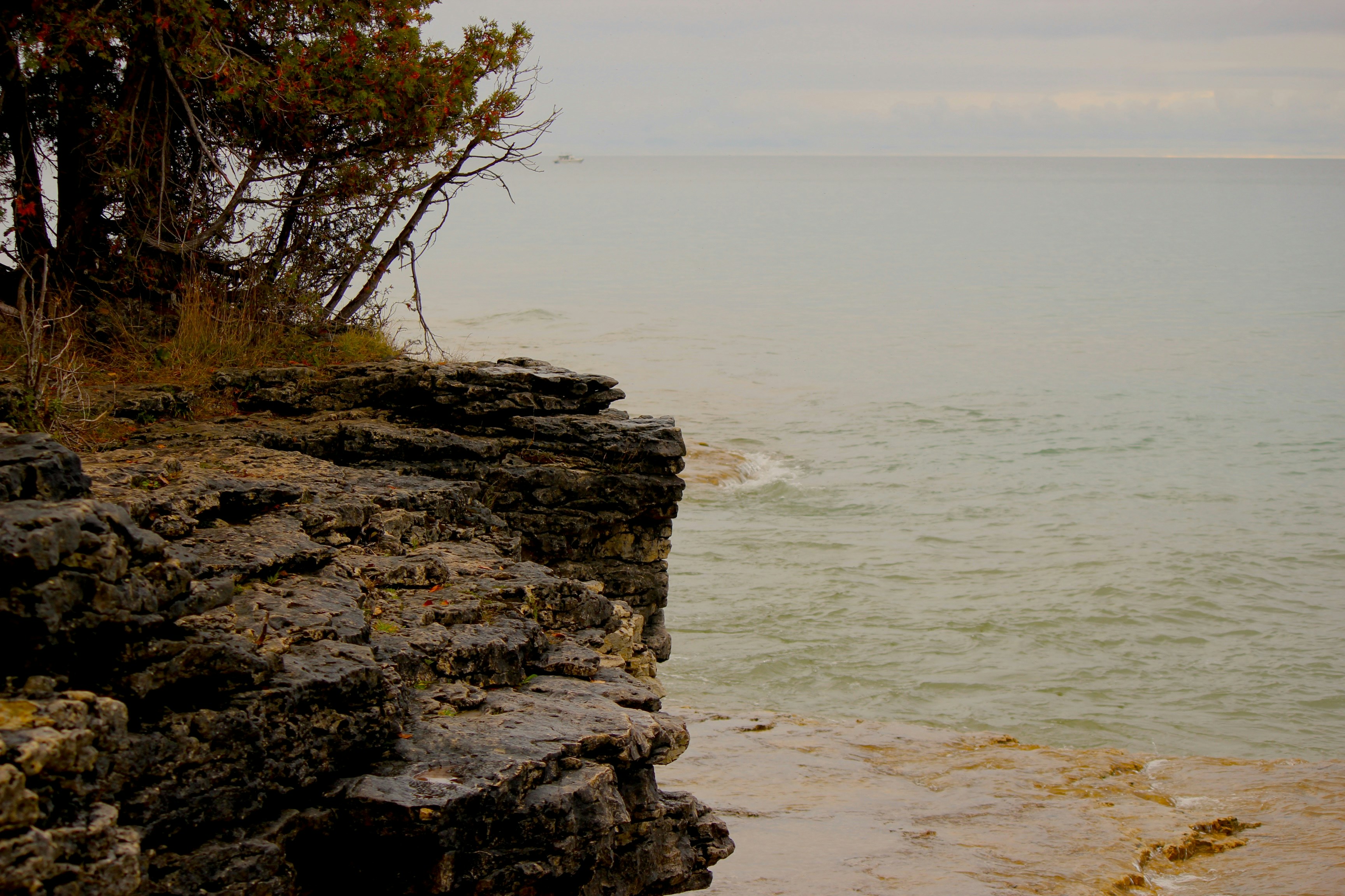 Cliffside Edge Over Calm Waters at Dusk