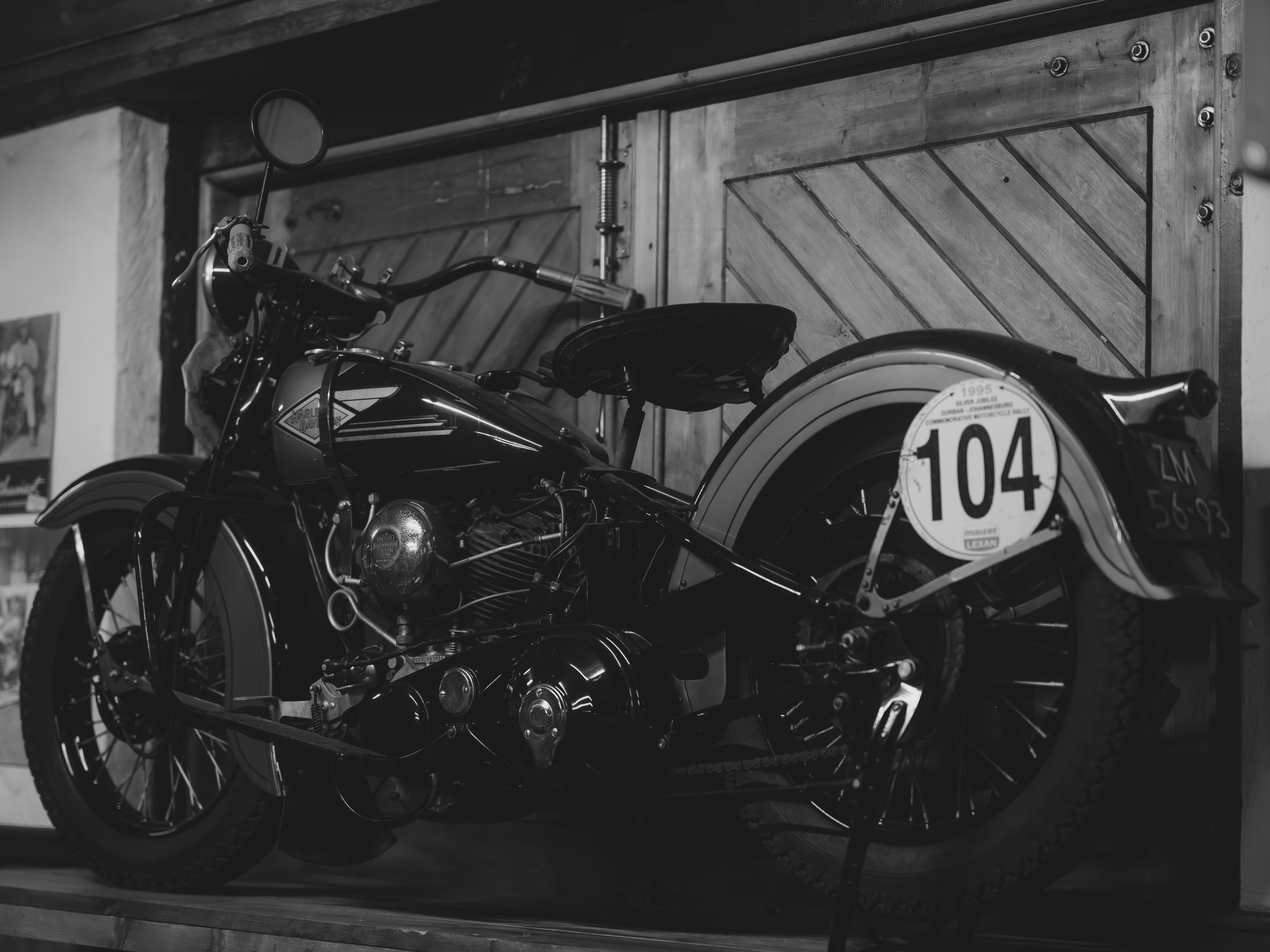 No. 104 in the Shadowed Garage: A Vintage Motorcycle Resting by a Wooden Door