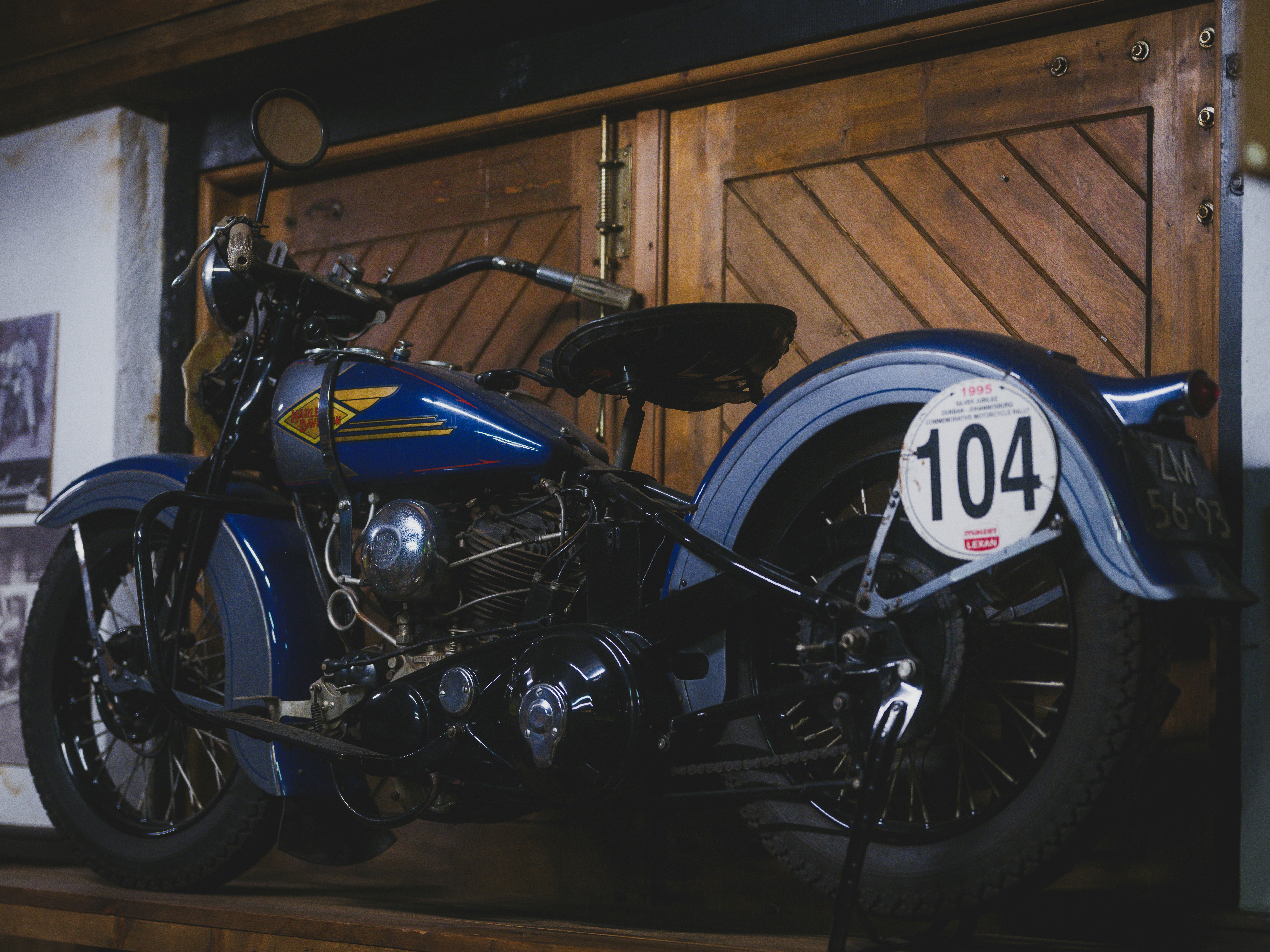 Blue Classic: Vintage Motorrad Resting by a Wooden Door