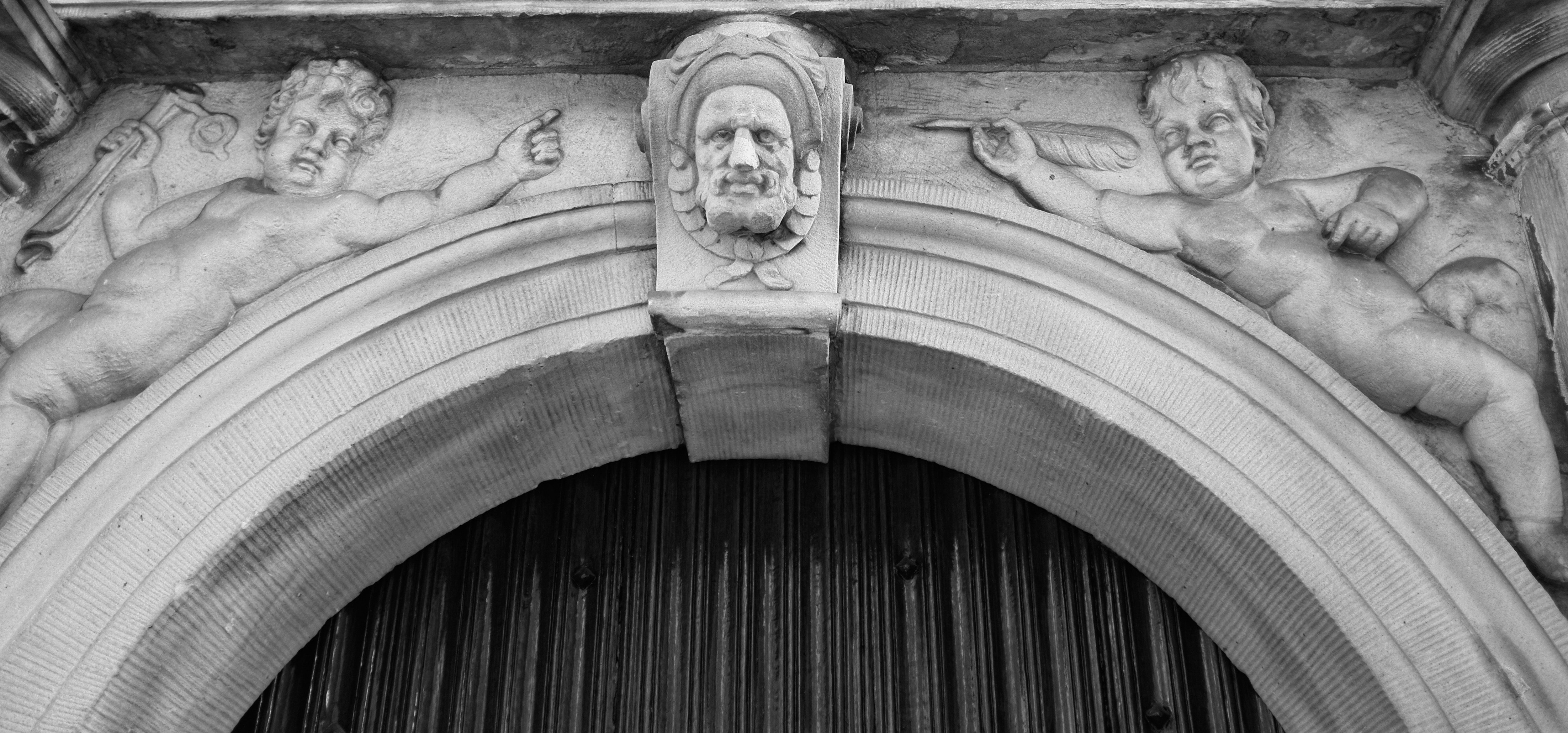 Stone Gatekeeper: A Marble Portrait Crowned by Arch and Figurines