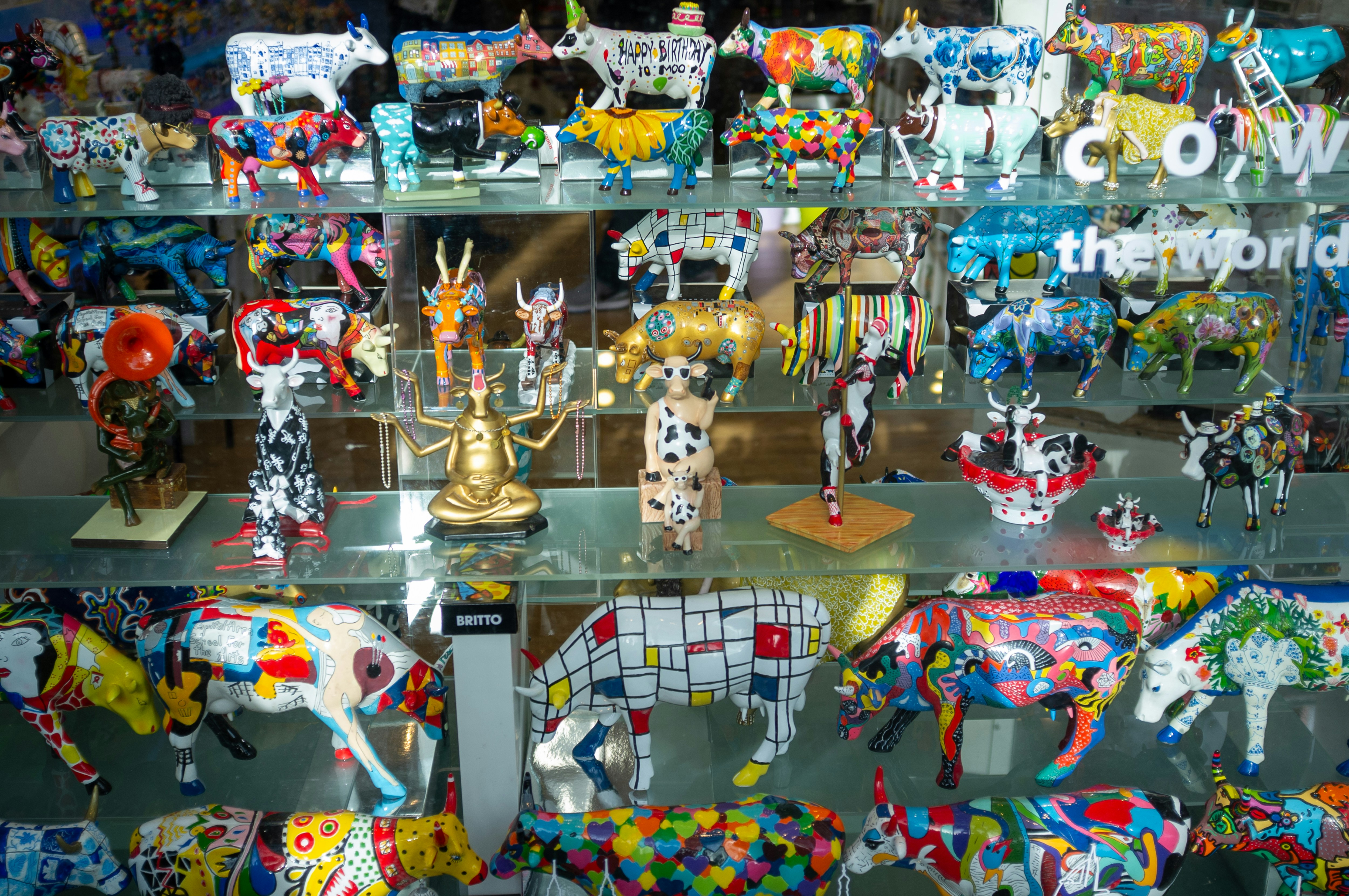 Colorful Creatures on Glass Shelves: A Carnival of Decorated Figures