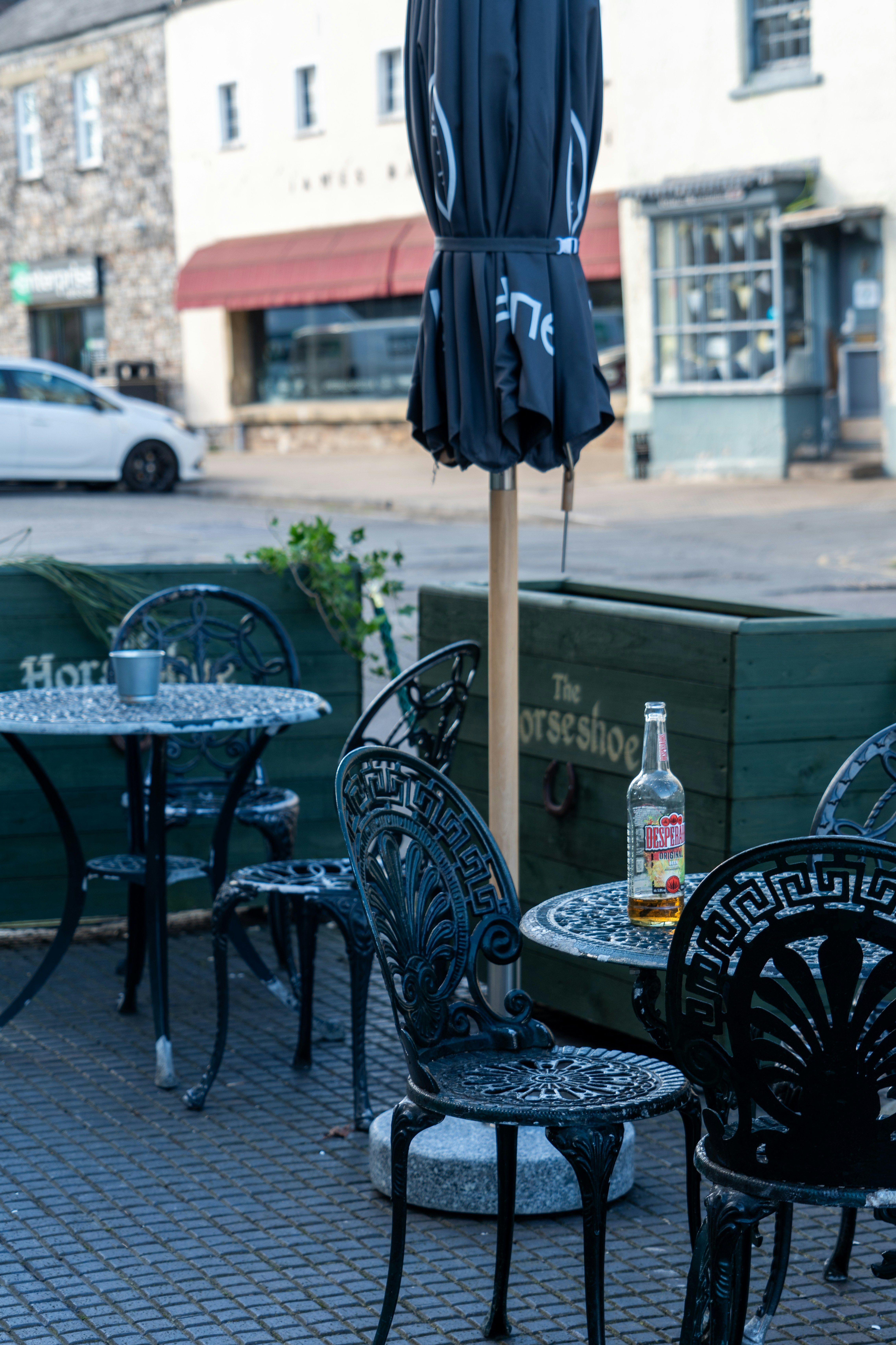 Abandoned Bottle on a Quiet Outdoor Café Table
