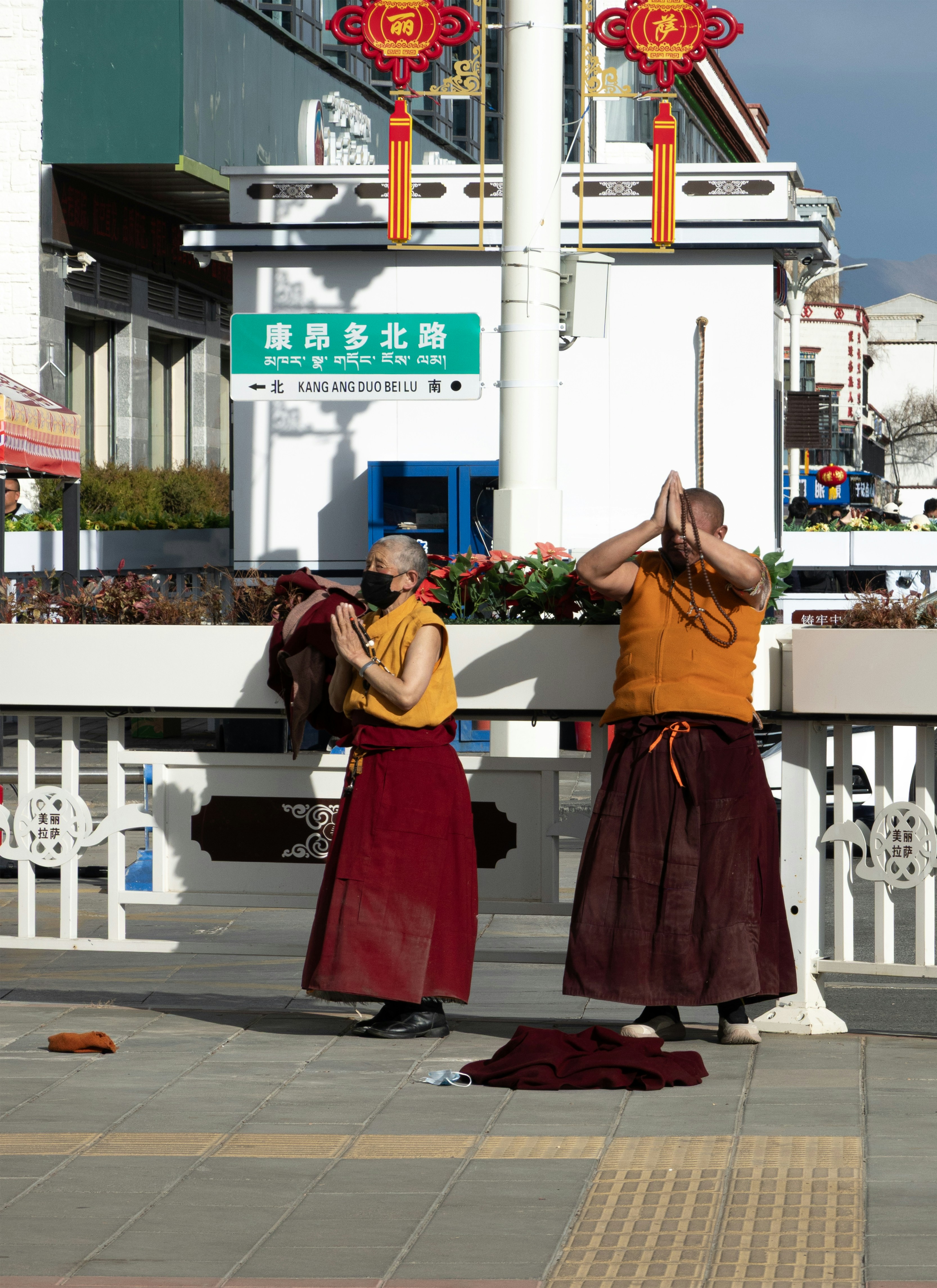 Monks in Orange Robes Perform Morning Ritual by a Chinese Street Scene