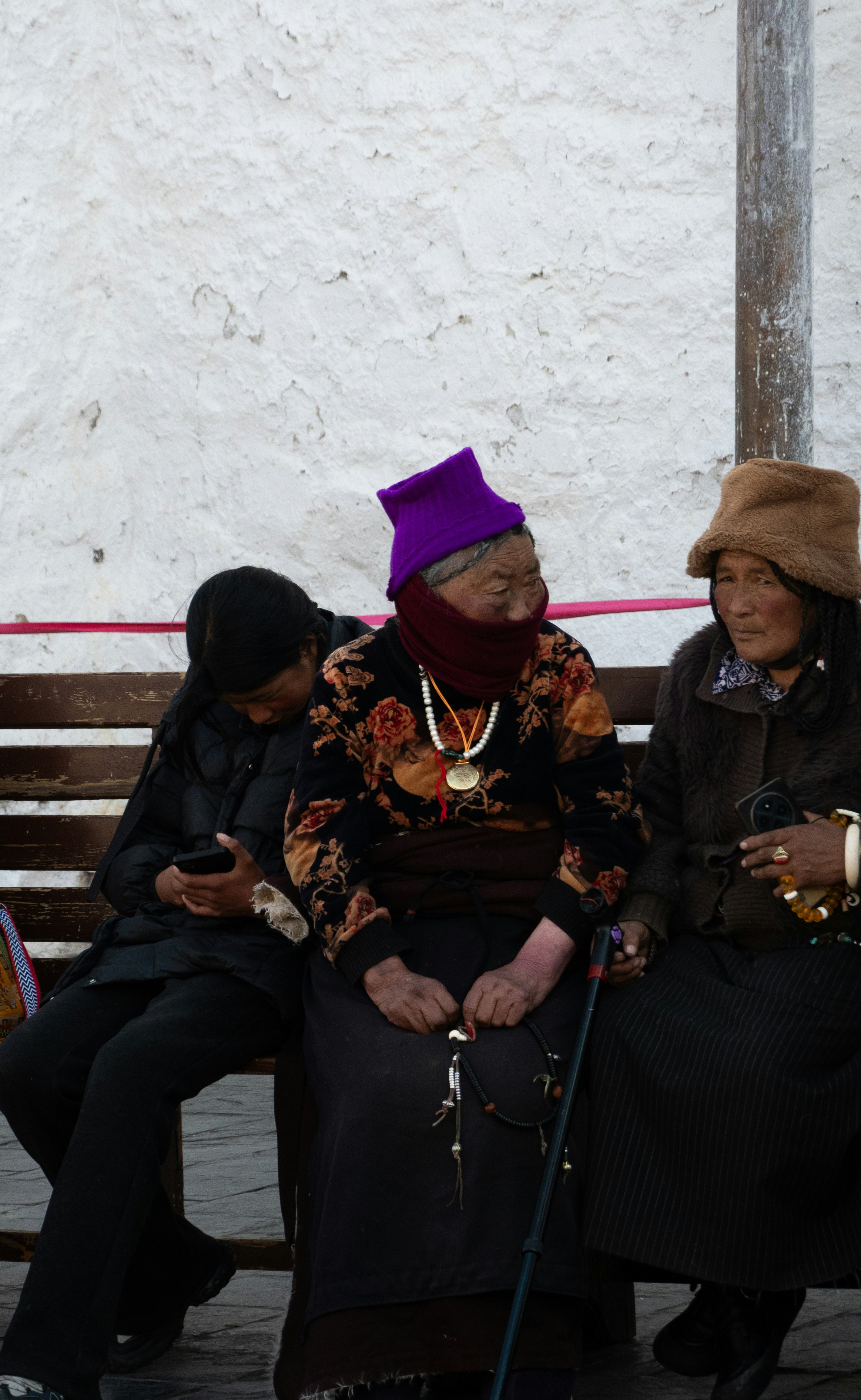 Three Elders on a Bench: Colorful Hats and Quiet Conversation
