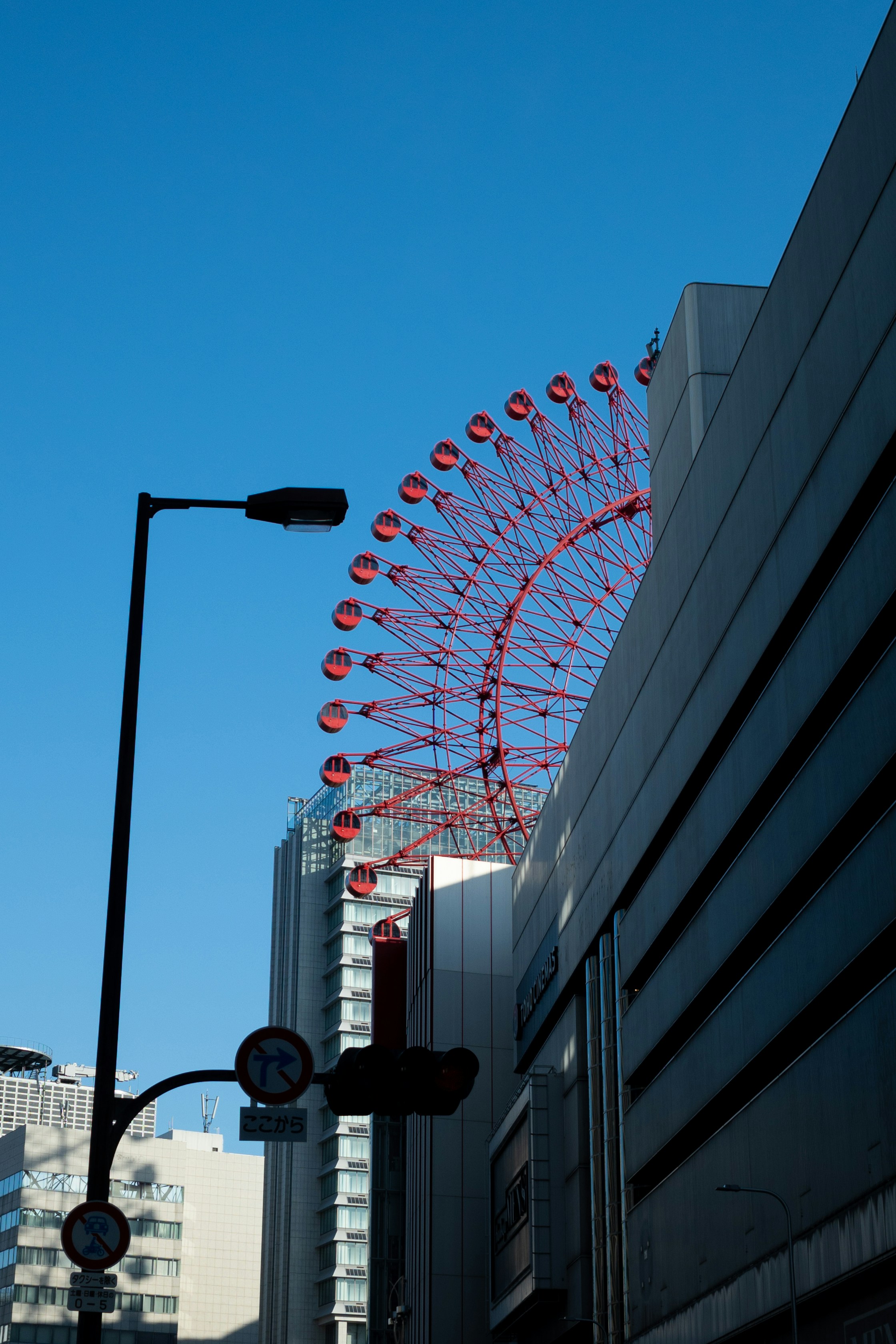 Ferris Wheel Silhouette Beyond Urban Facades