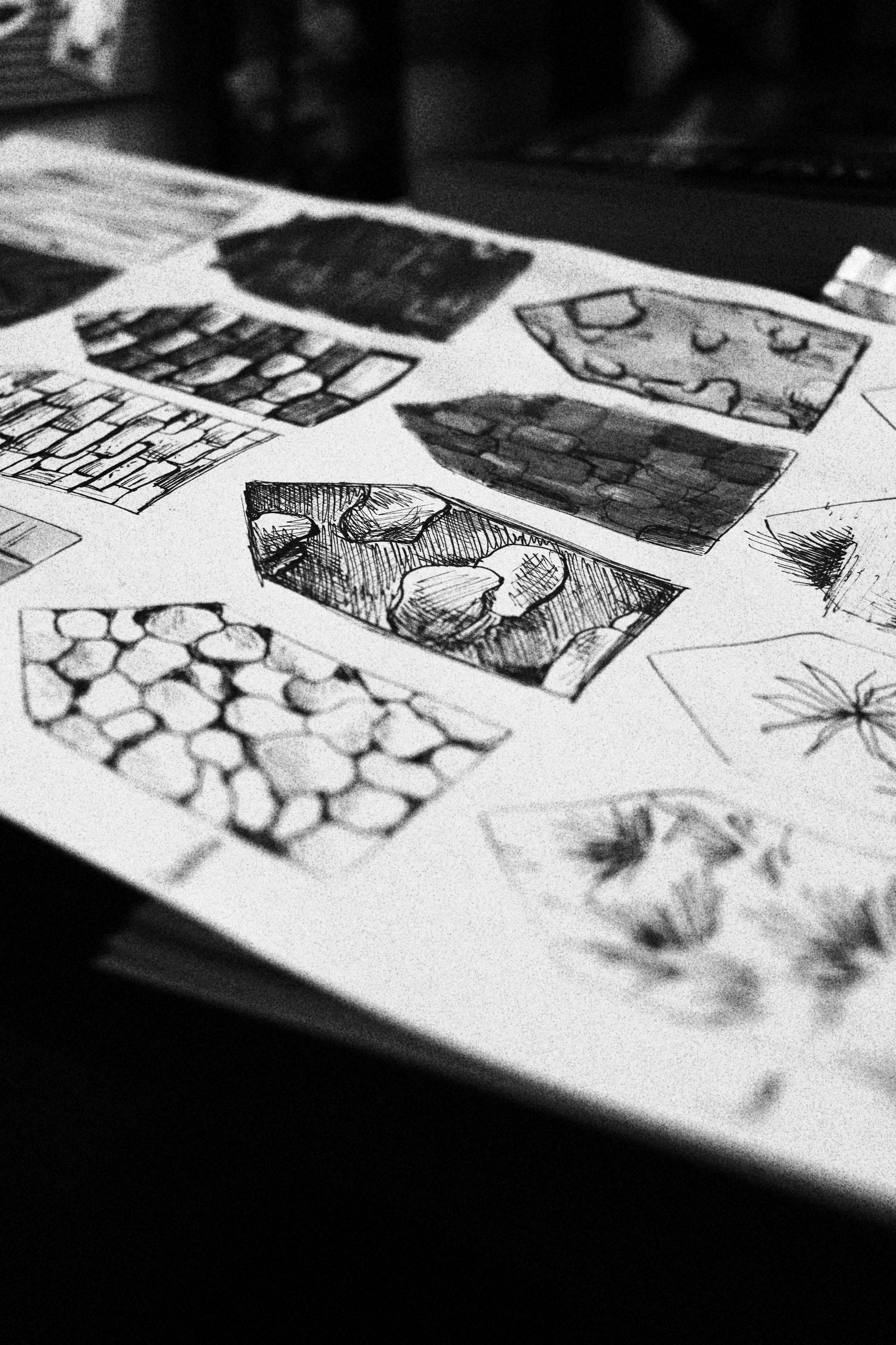 Close-up of a sheet with various hand-drawn geometric textures and textures, focusing on line work and shading.
