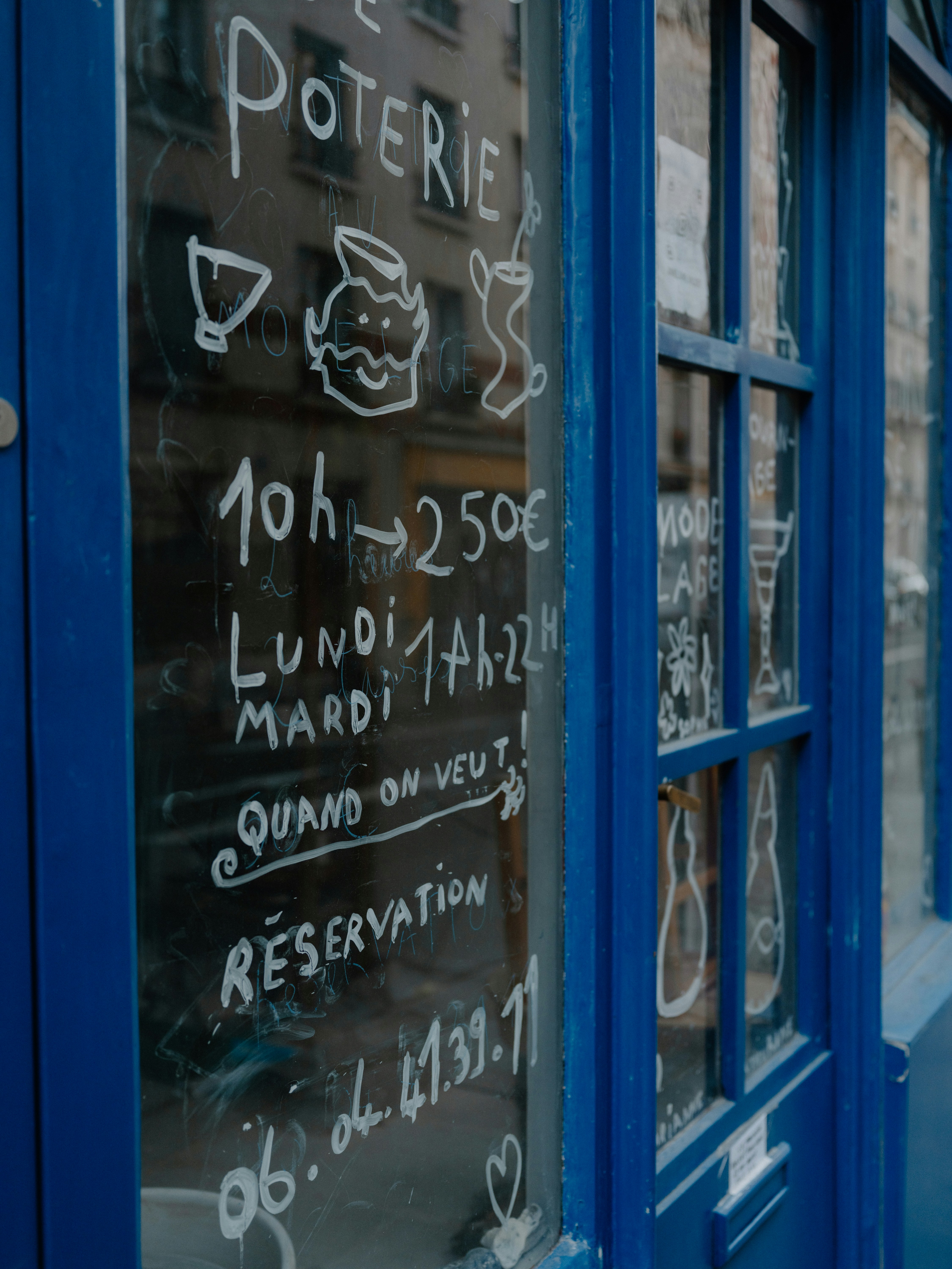 Blue storefront glass whispers with chalked menu and drawings