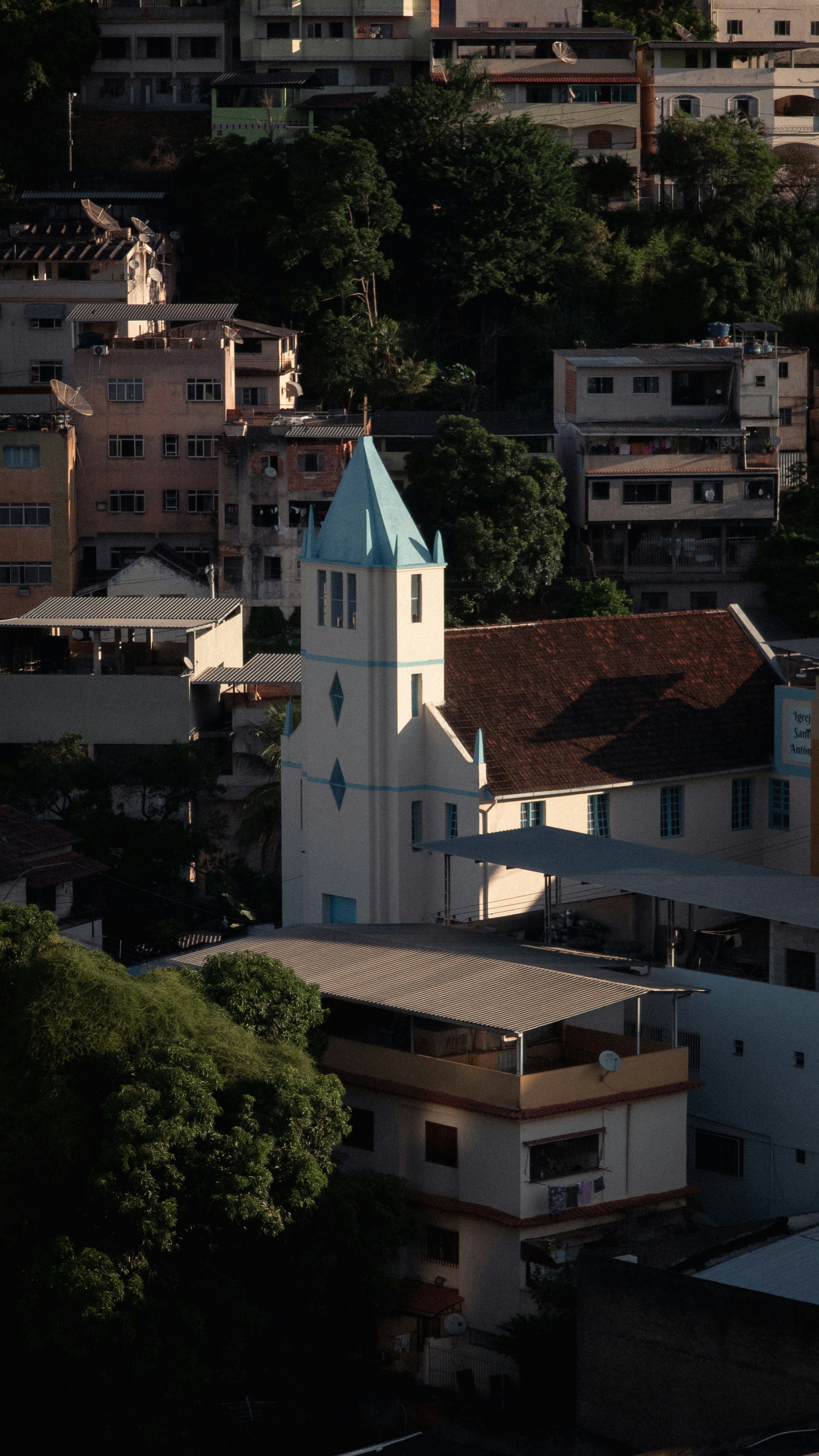 White church spire rising through a hillside of urban blocks