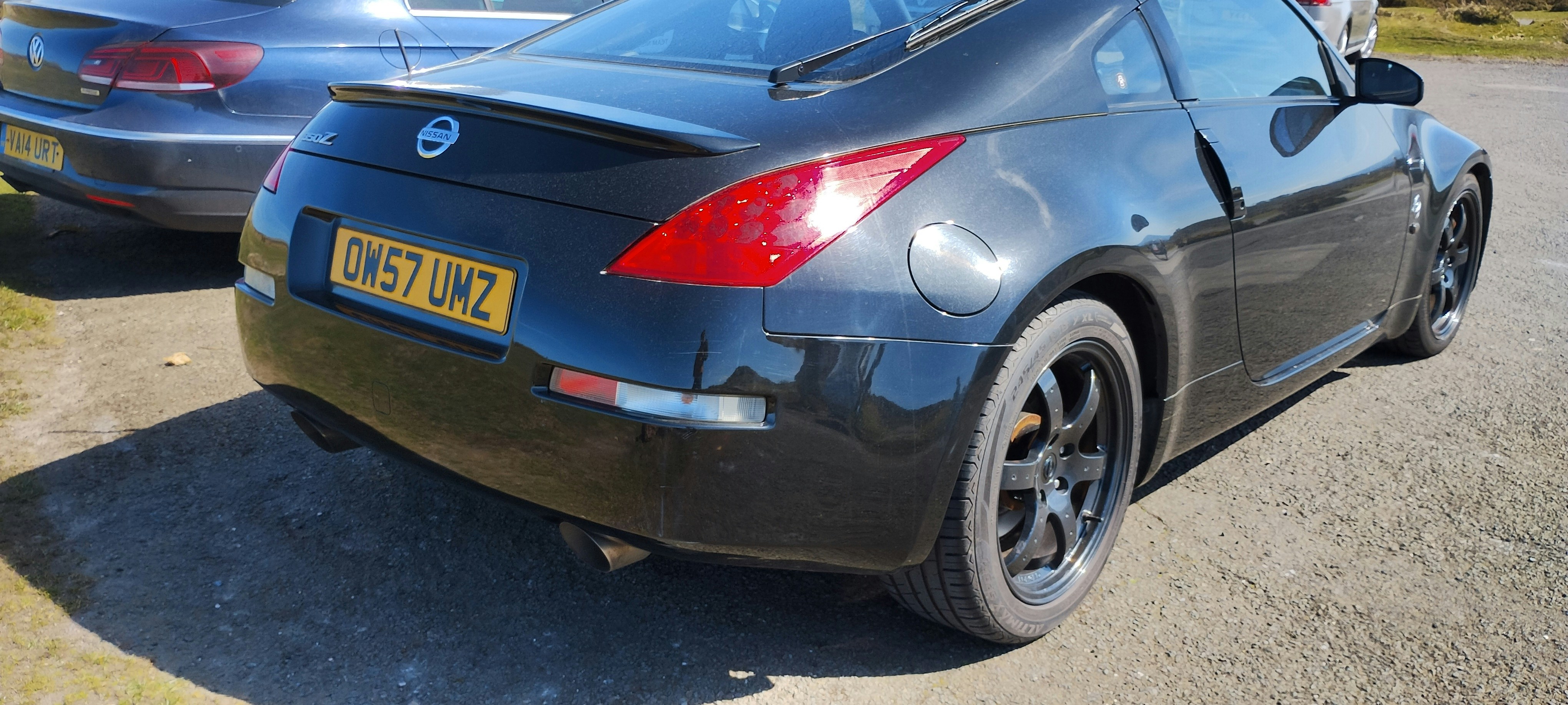 Dark sports coupe with a vibrant red rear light and visible license plate