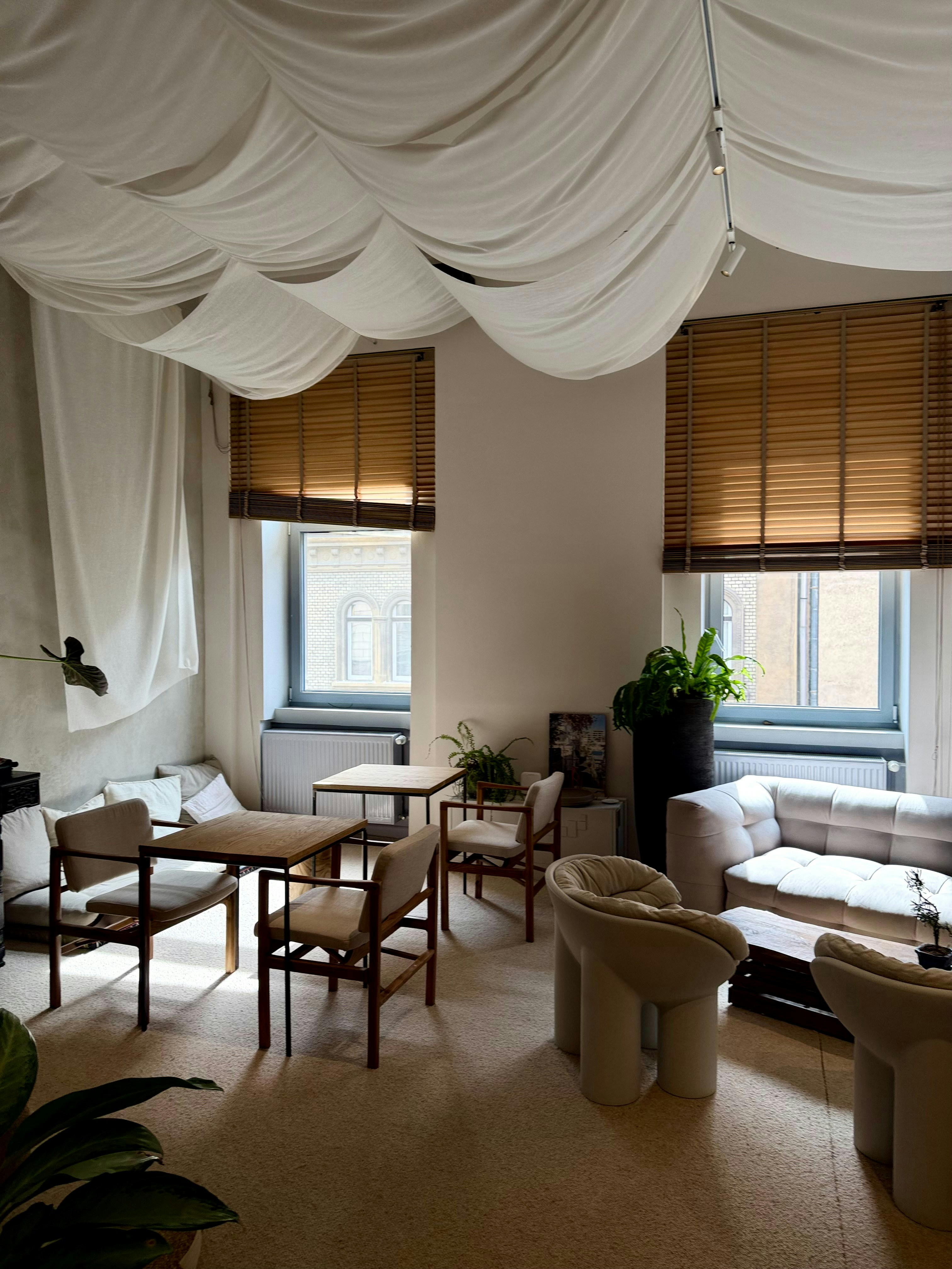 Sunlit Lounge with Draped Ceiling and Mid-Century Seating