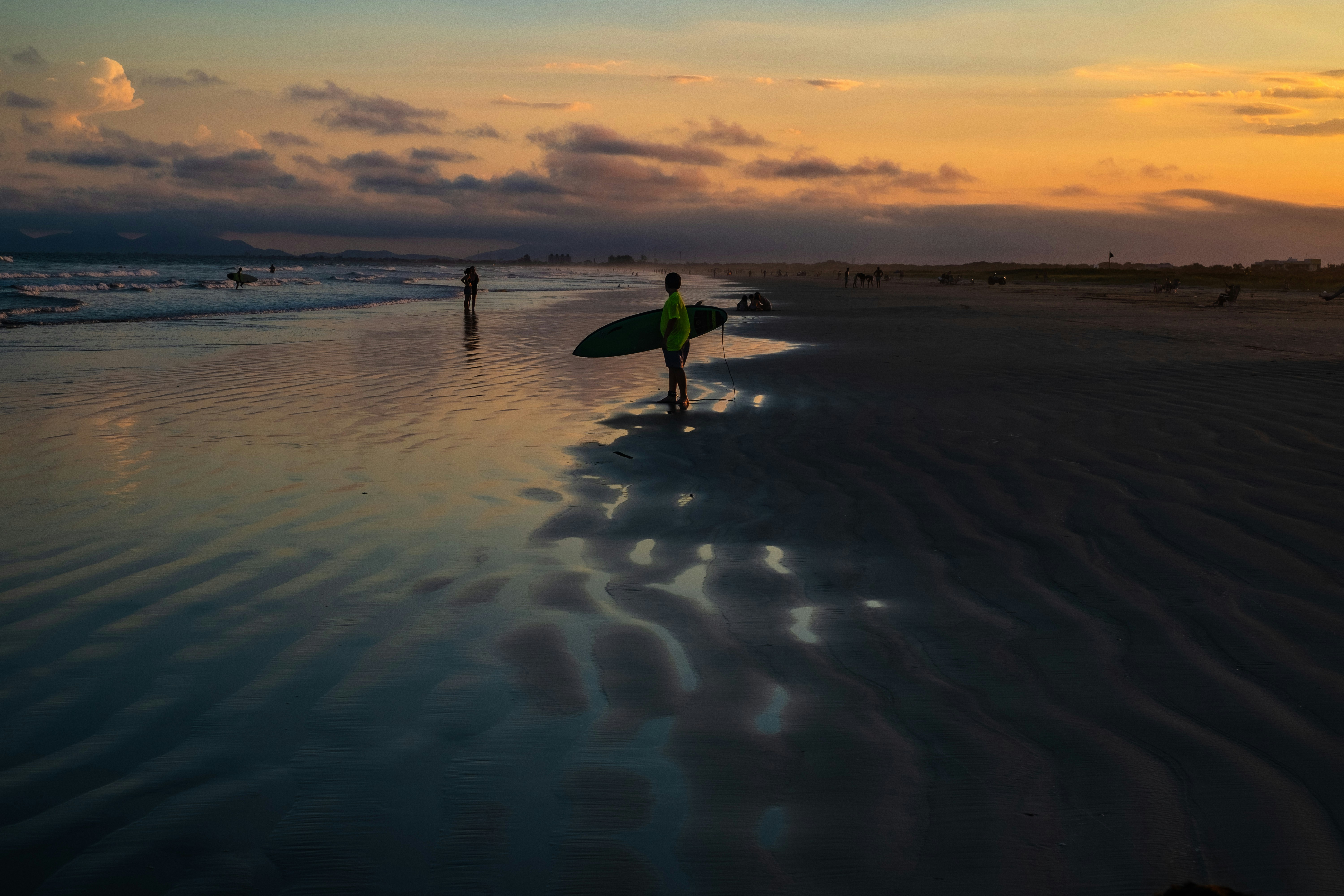 Surfer at Dusk: Silhouettes on a Velvet Shore