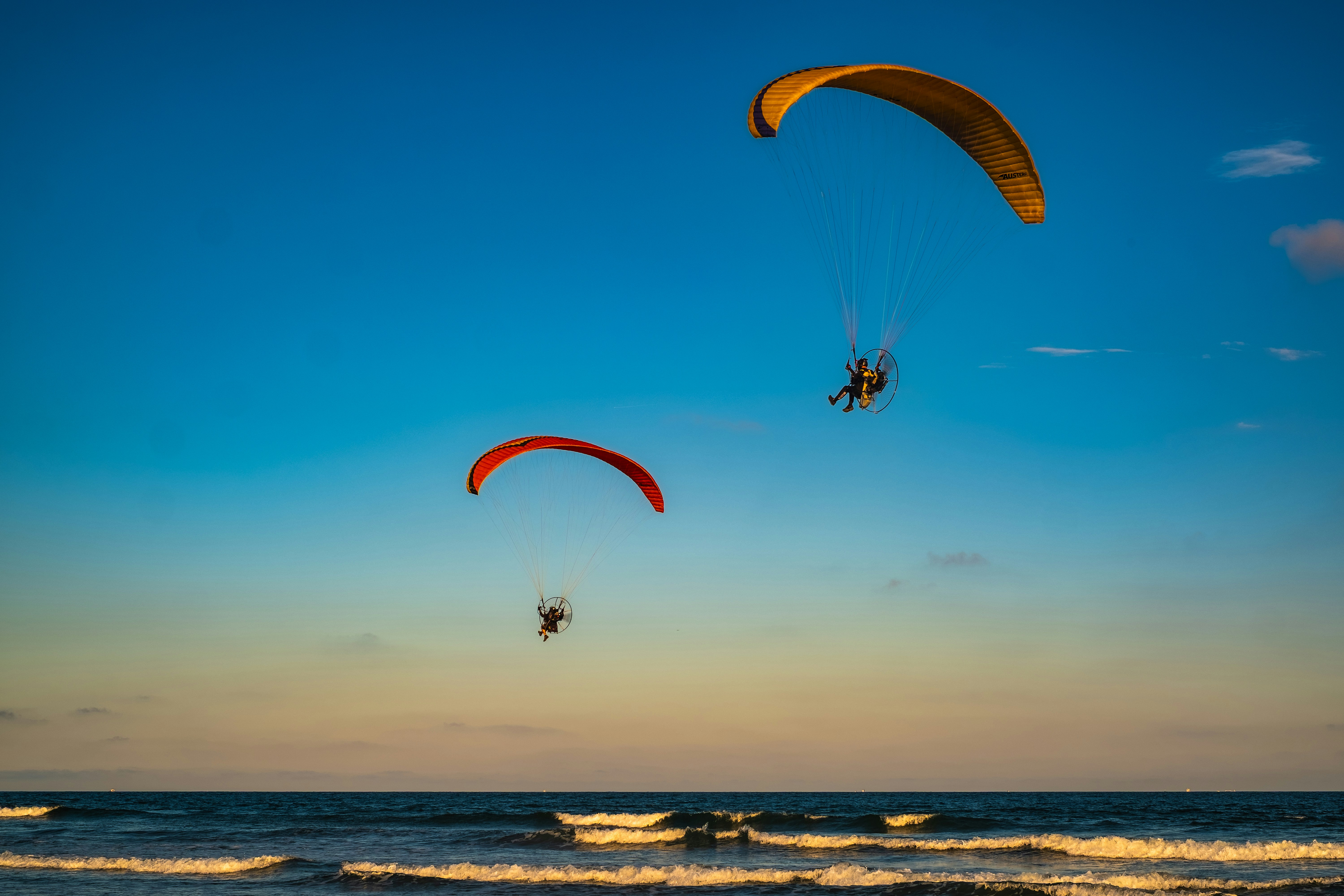Over Ocean Dawn: Twin Paragliders Soar Above Quiet Waves