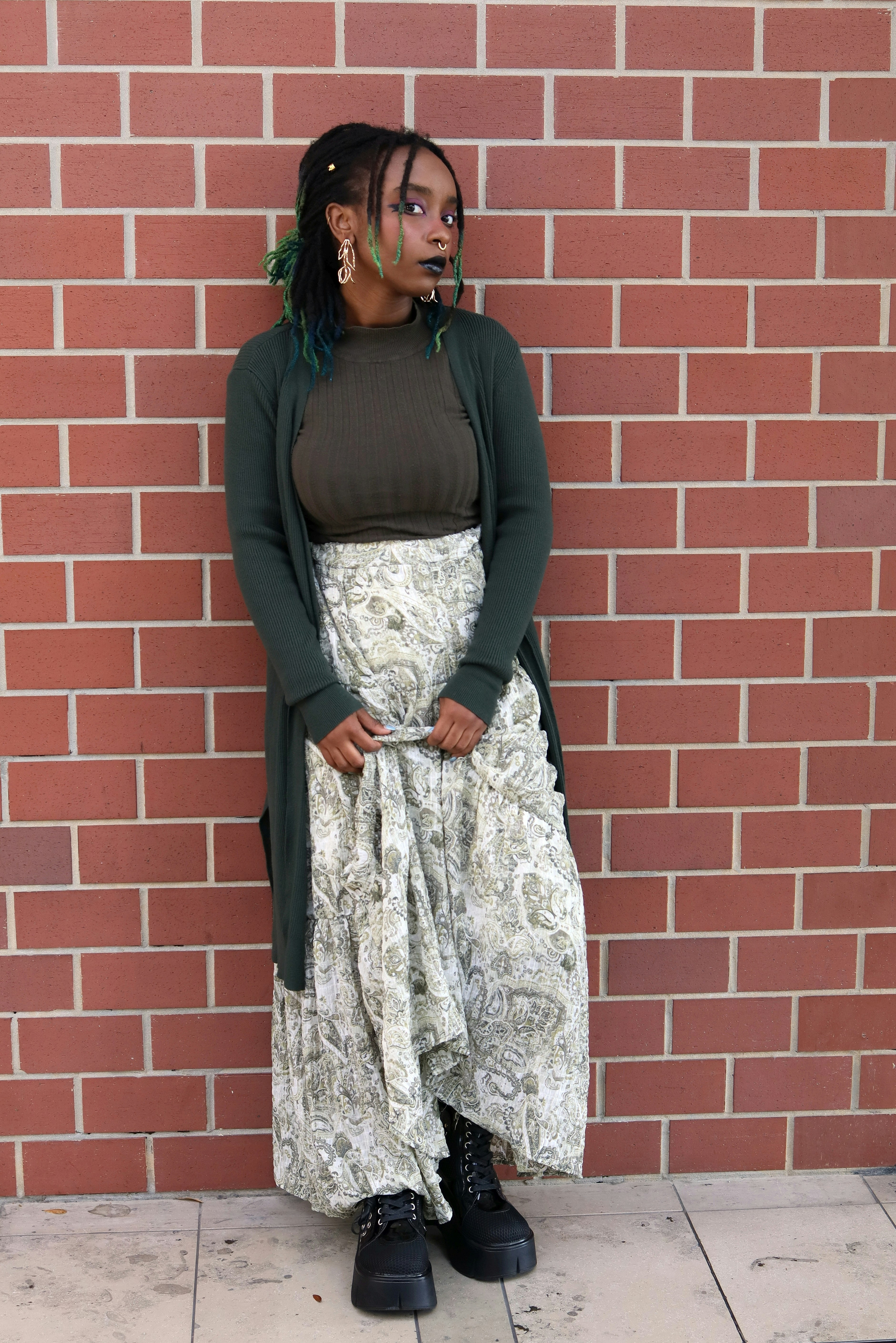 Brick Wall Portrait: A Woman in Earth Tones with Flowing Skirt and Bold Accessories