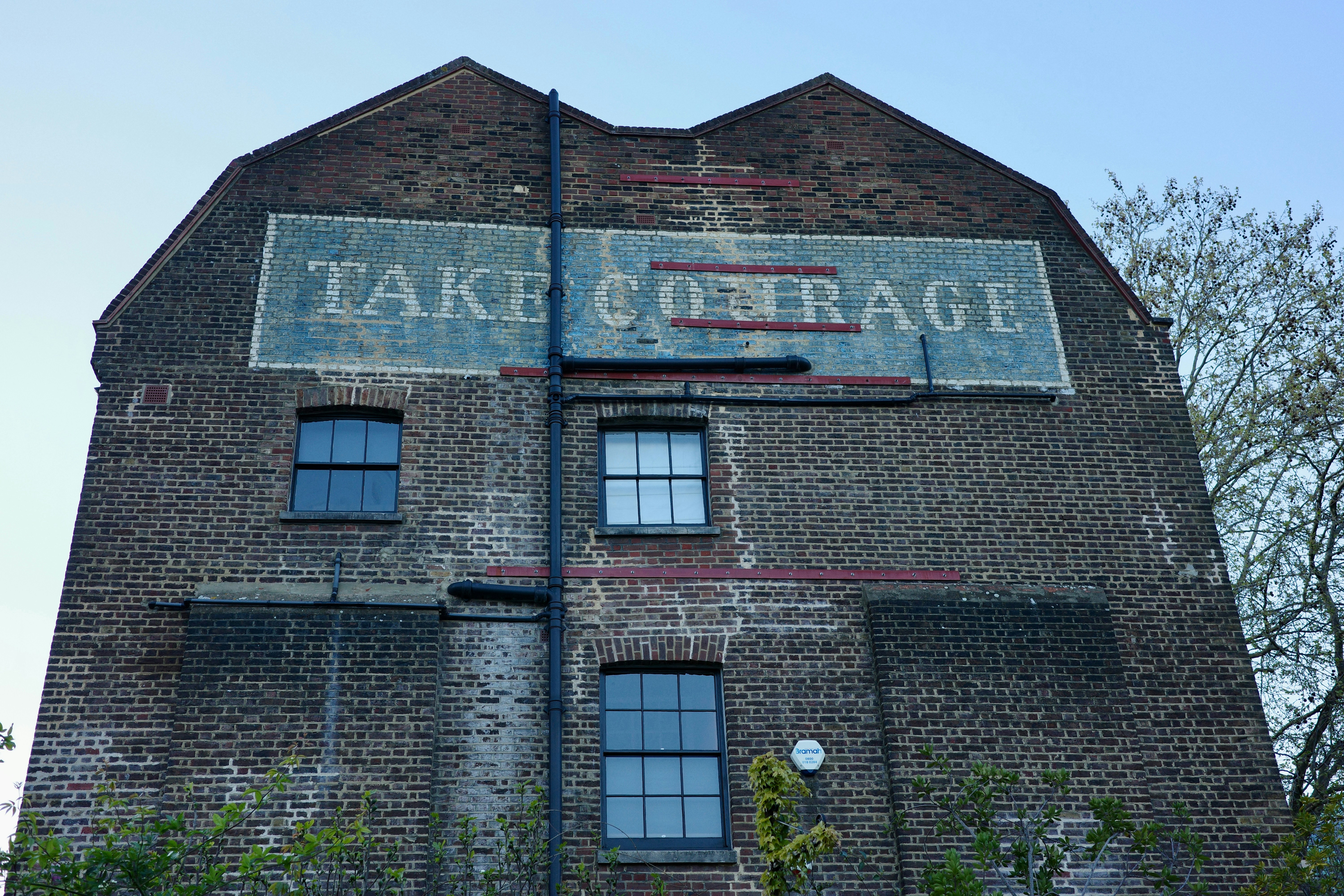 Brick Facade Reclaim: Weathered Sign Across a Stately Warehouse