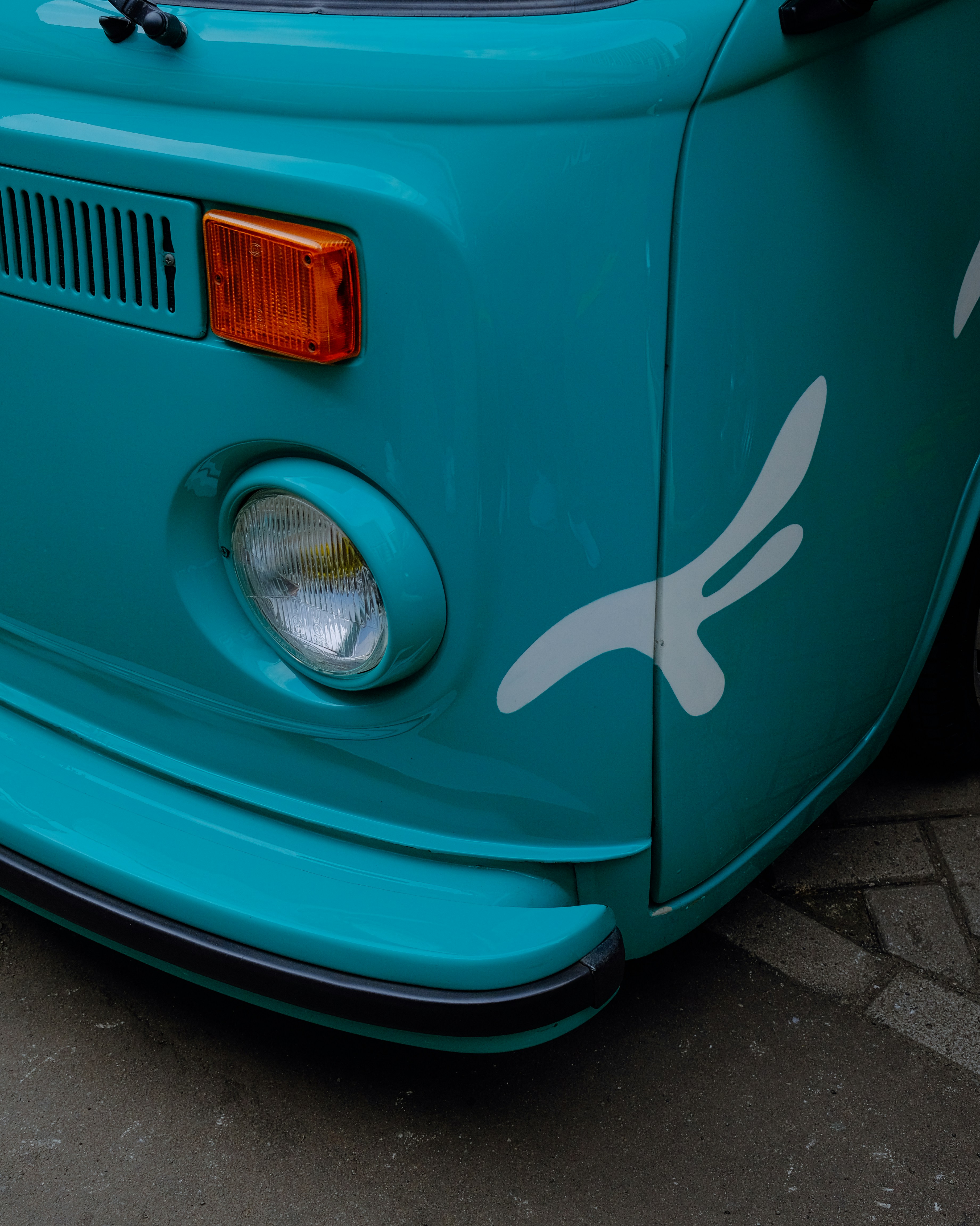 Turquoise van front: a glossy streamline with a white splash motif
