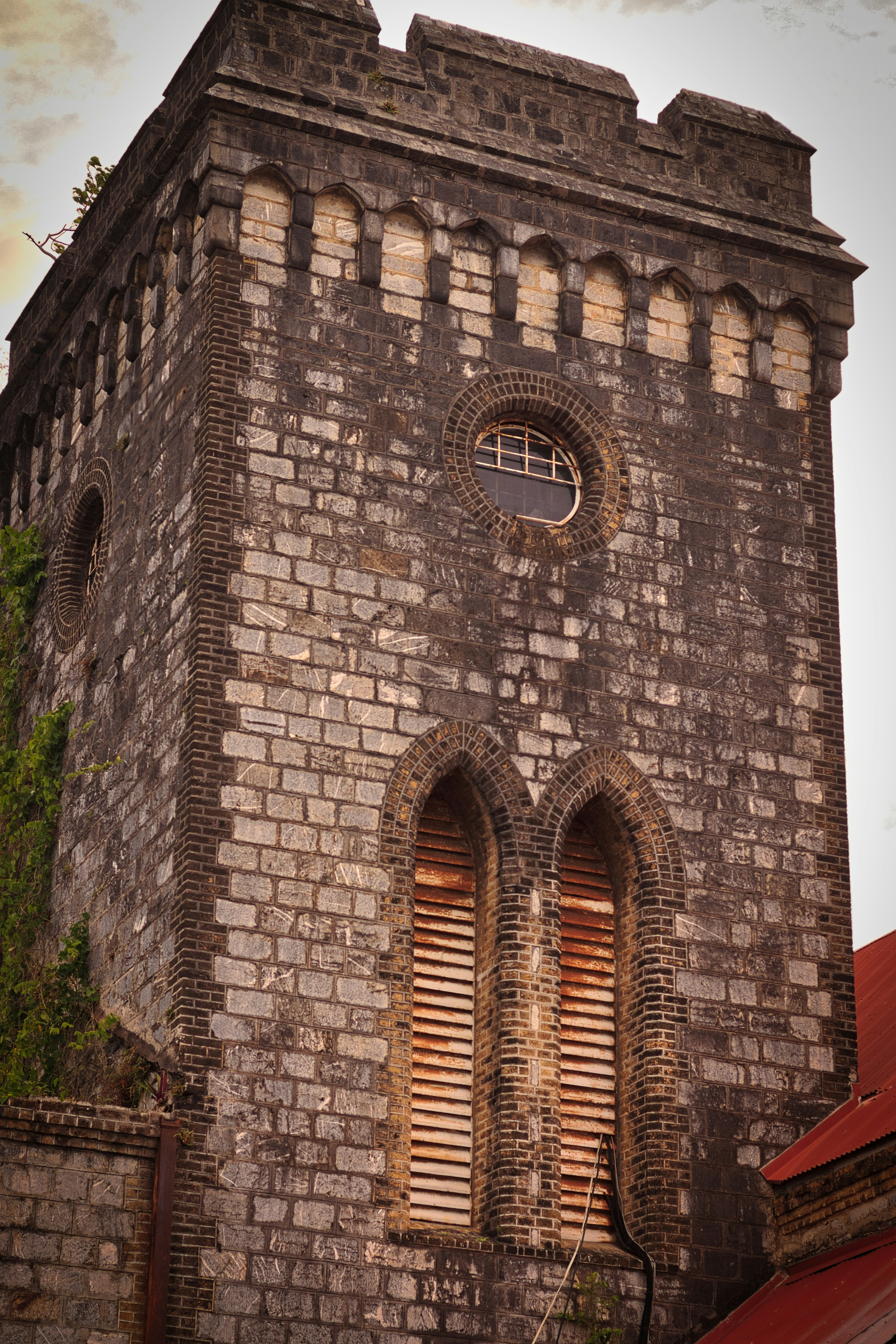 Stone Watchtower with Arched Windows Under a Cloudy Sky
