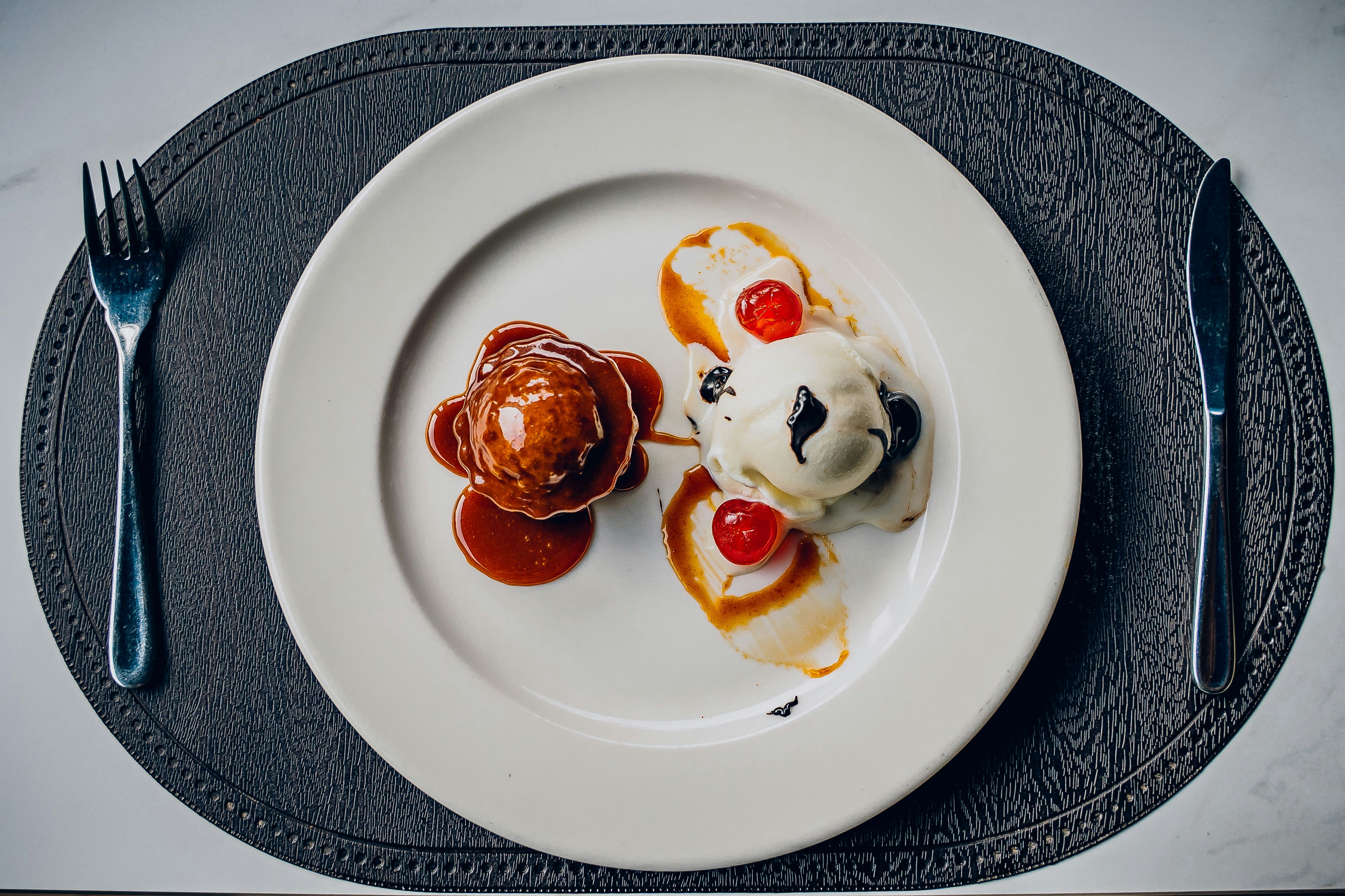 A Duo of Desserts: Petite pastry and a scoop of vanilla glaze on a white plate