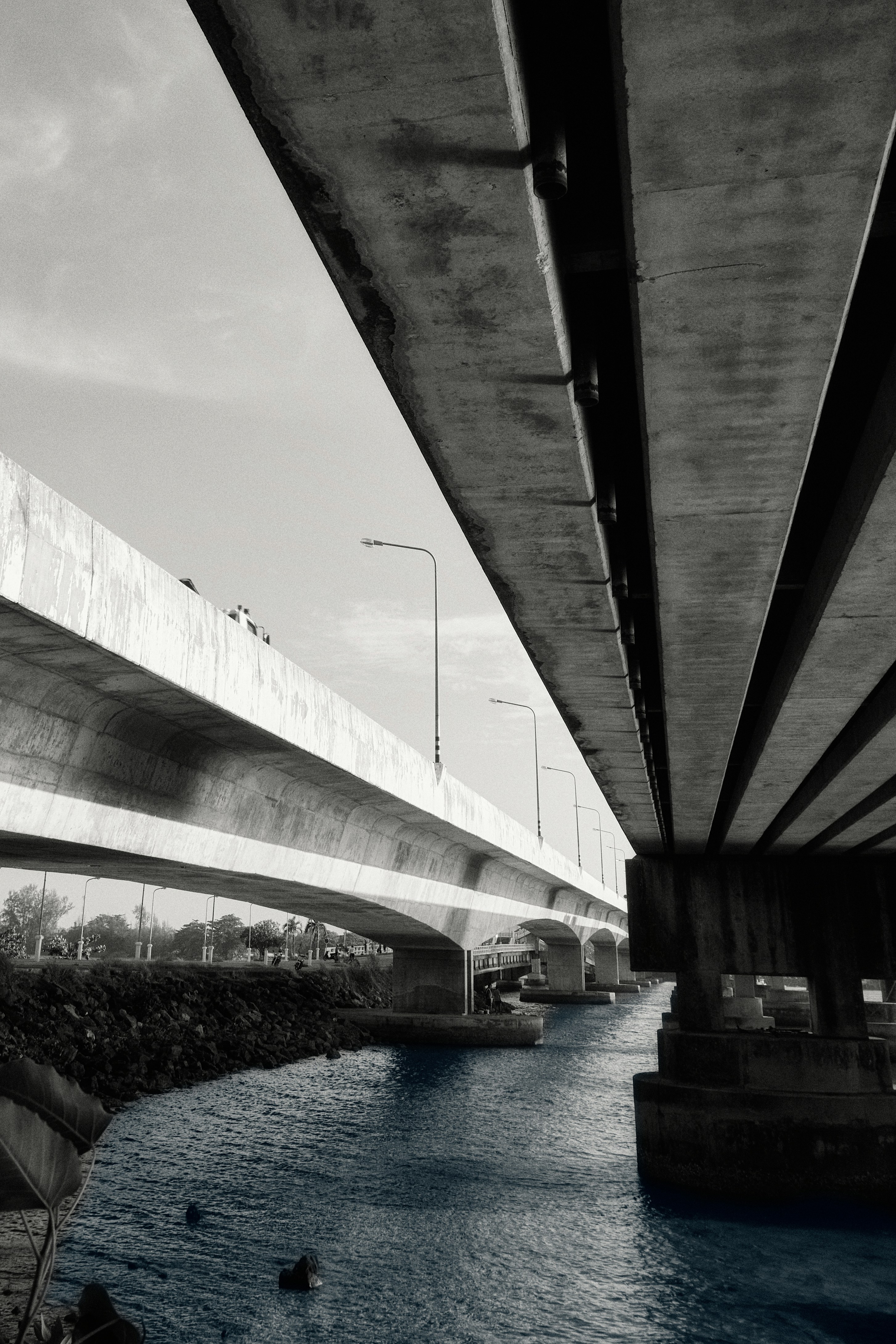 Under the Long Shadow: A Mono Bridge Corridor Over Quiet Water