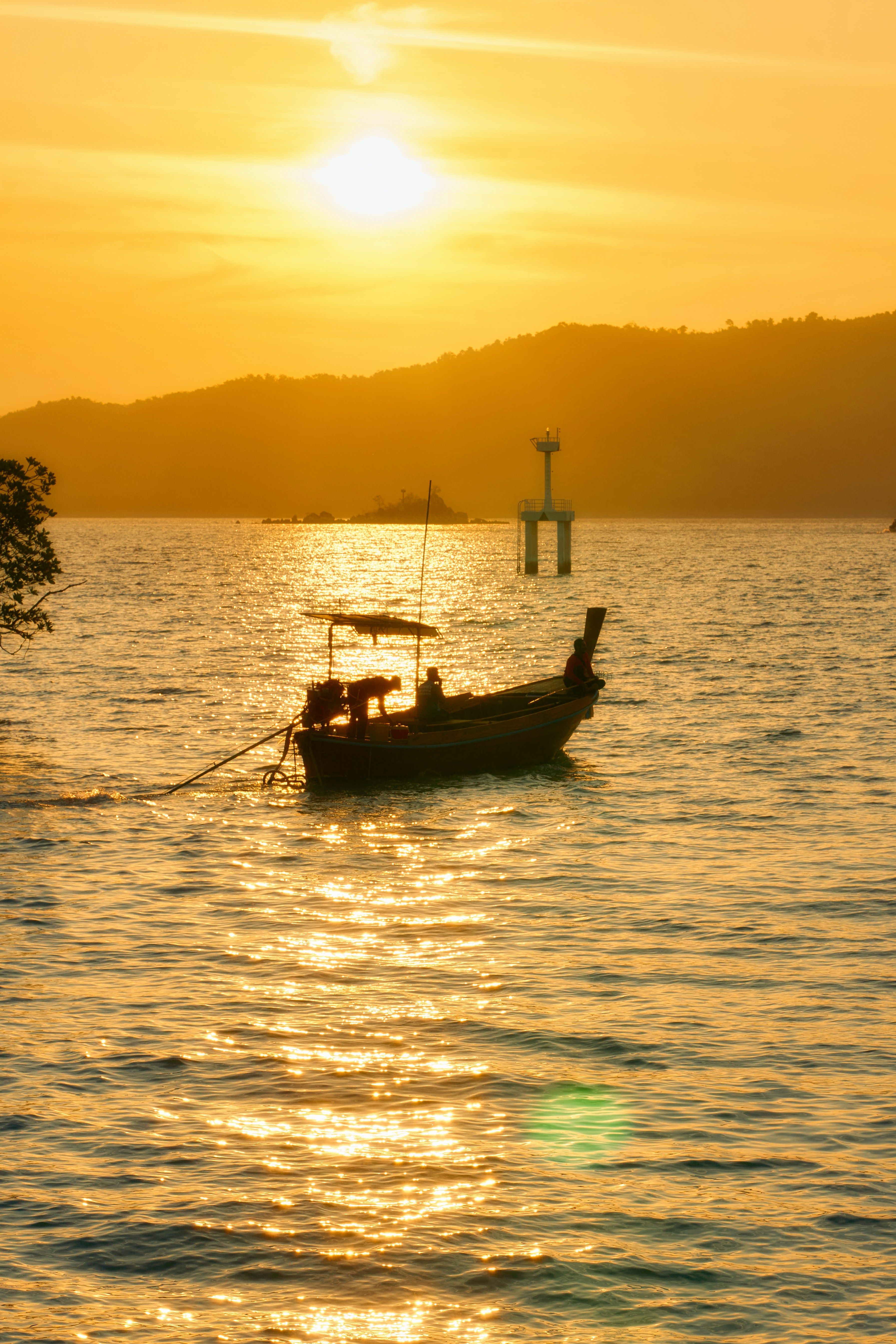 Sunlit Calm: A Sailboat Drifting in Golden Evening