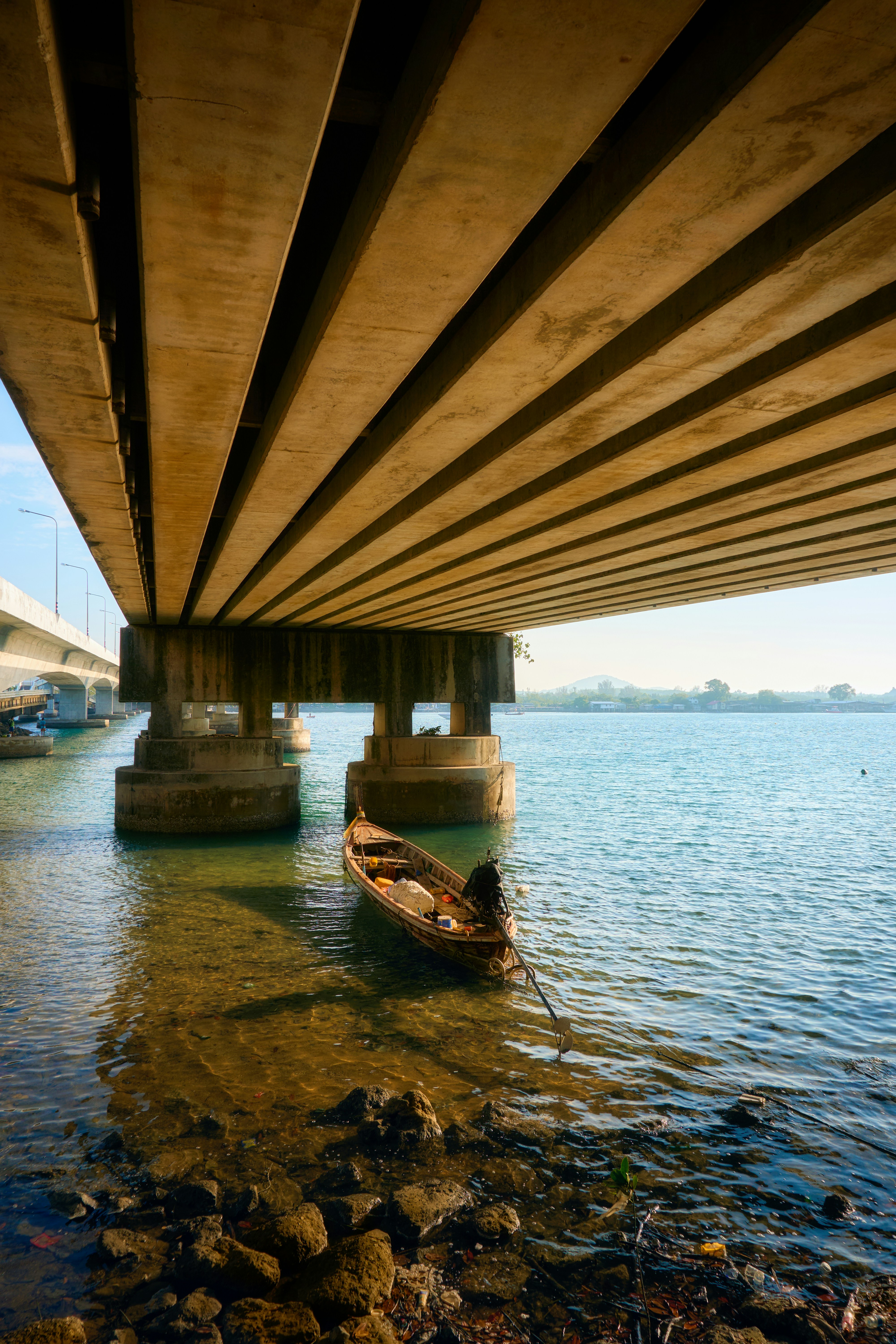 Under the Span: A Boat Tugging Through Afternoon Light
