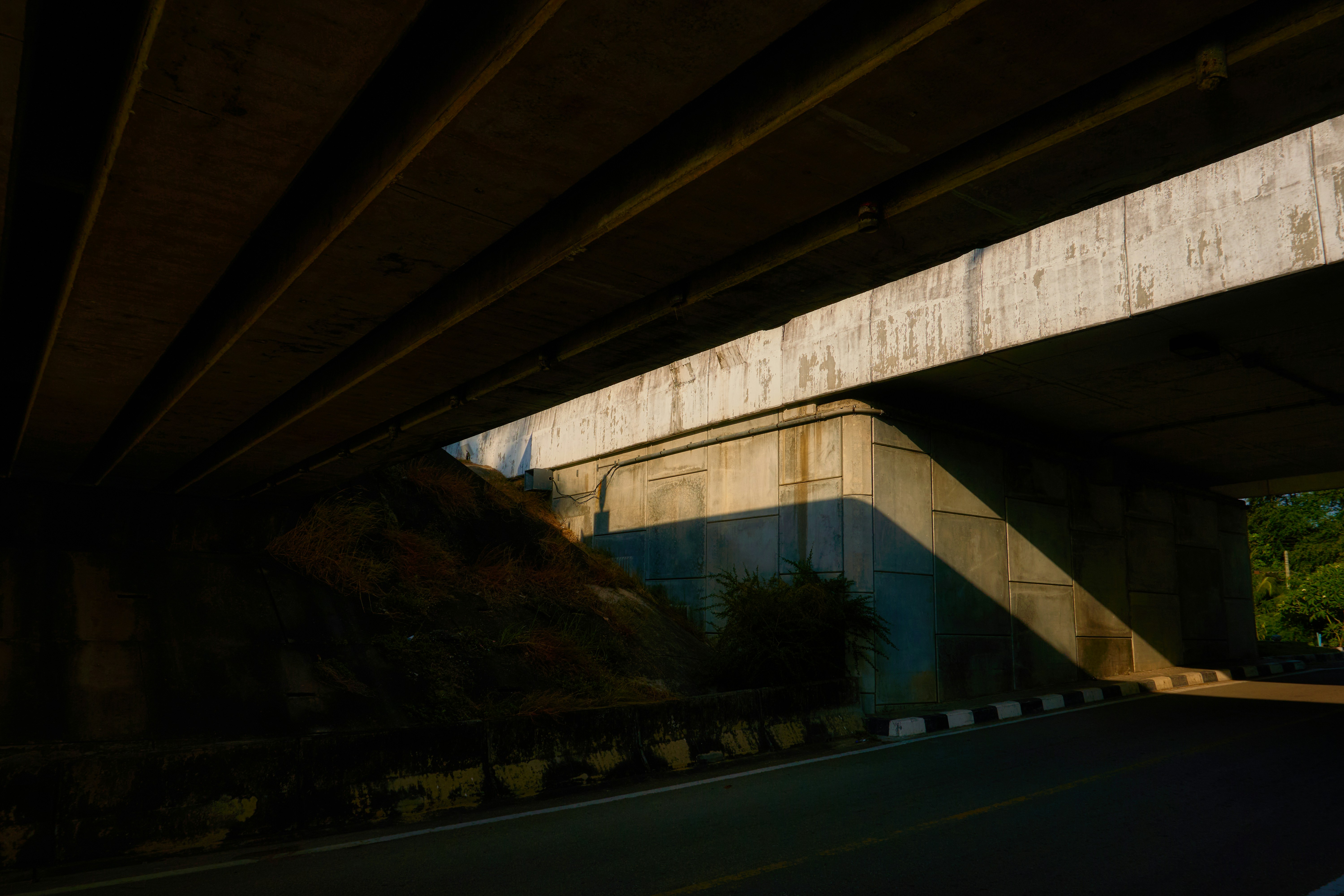 Shadowed Underpass: Light Stripes on Concrete Canyon