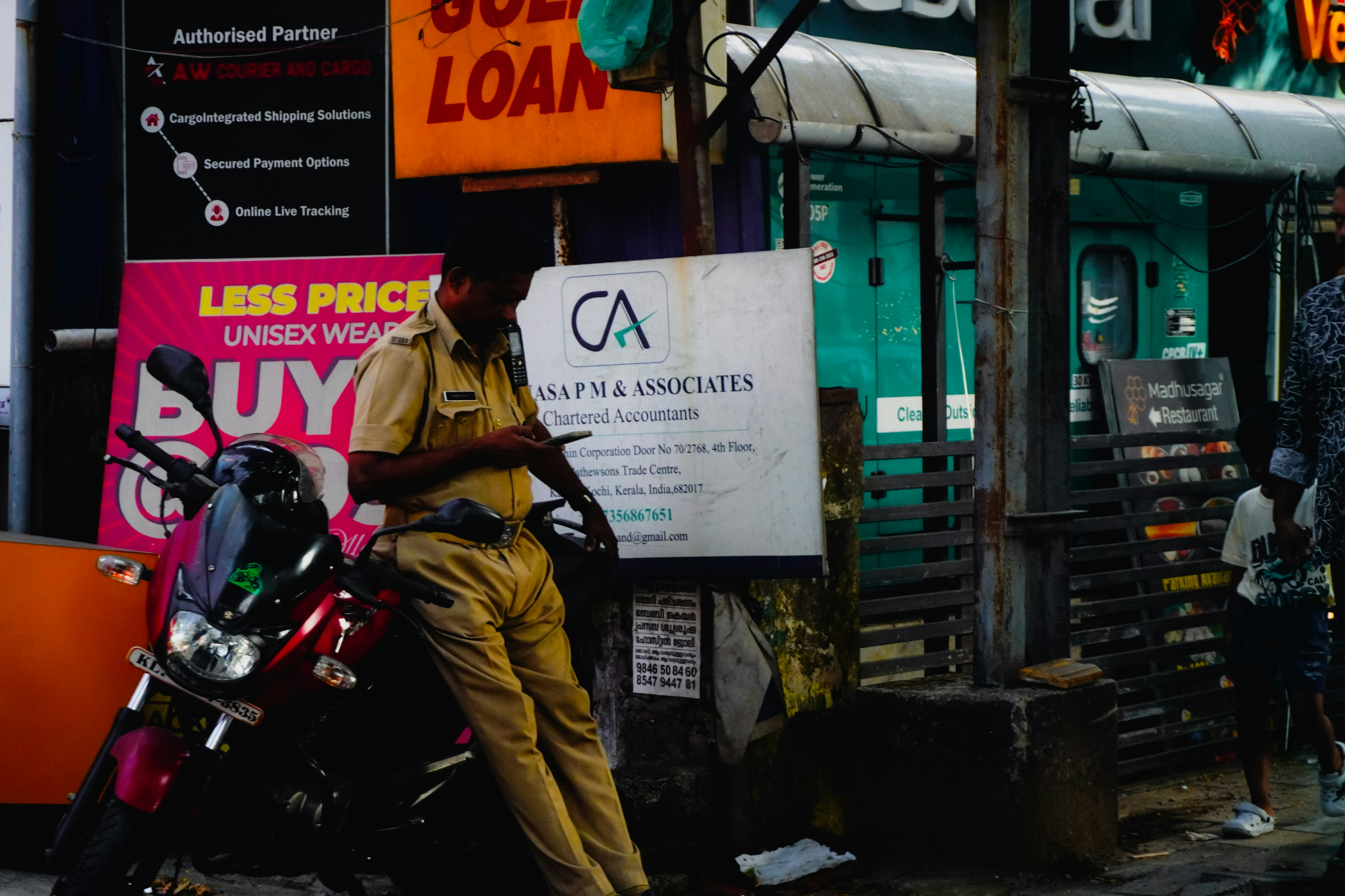 Street Clerk in Uniform Beside a Motorcycle by a Market Facade