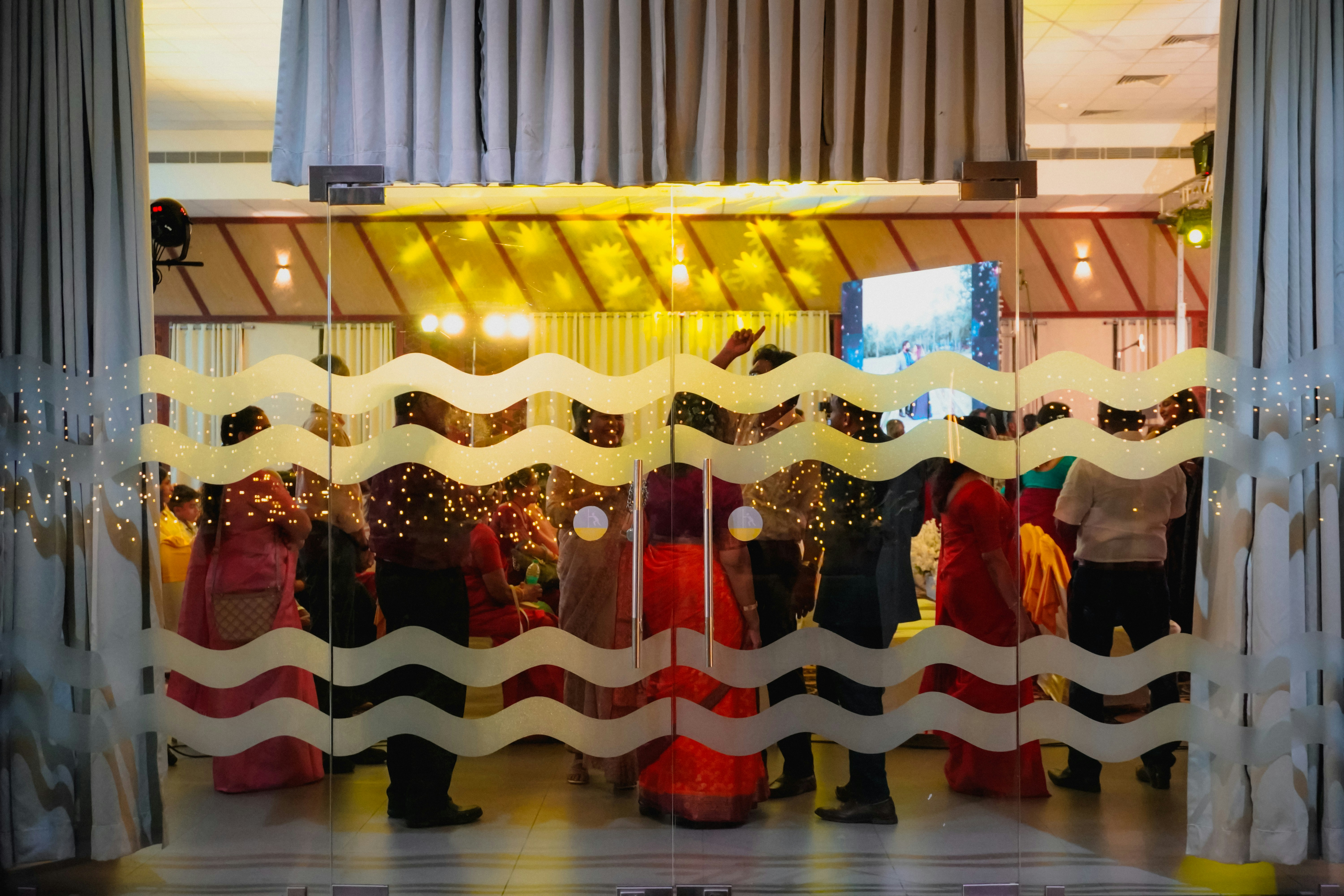 Curtain Up: A Glimpse Through Decorative Waves at a Celebration