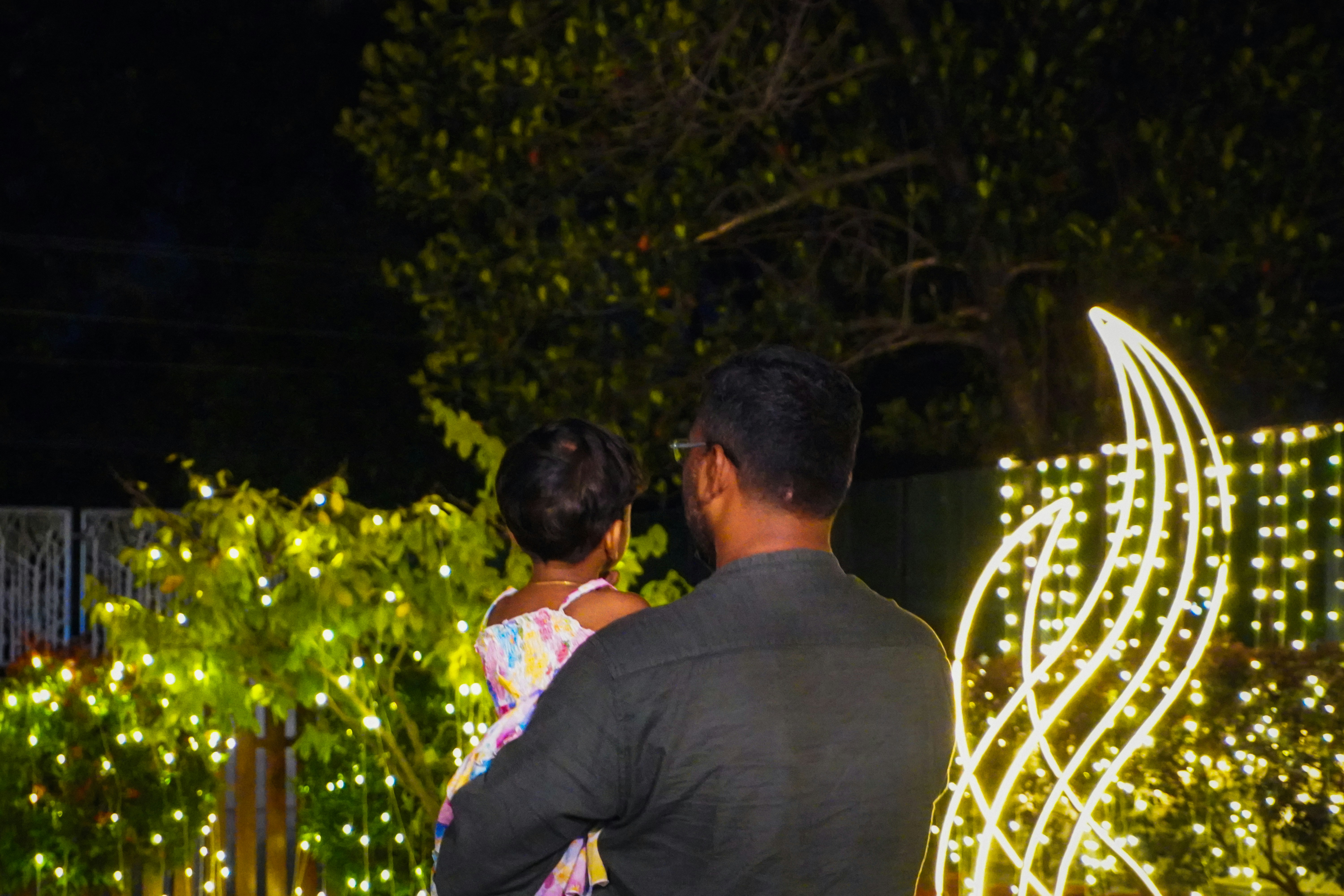Guiding Light: A Father Carries Hope Under Nighttime Neon