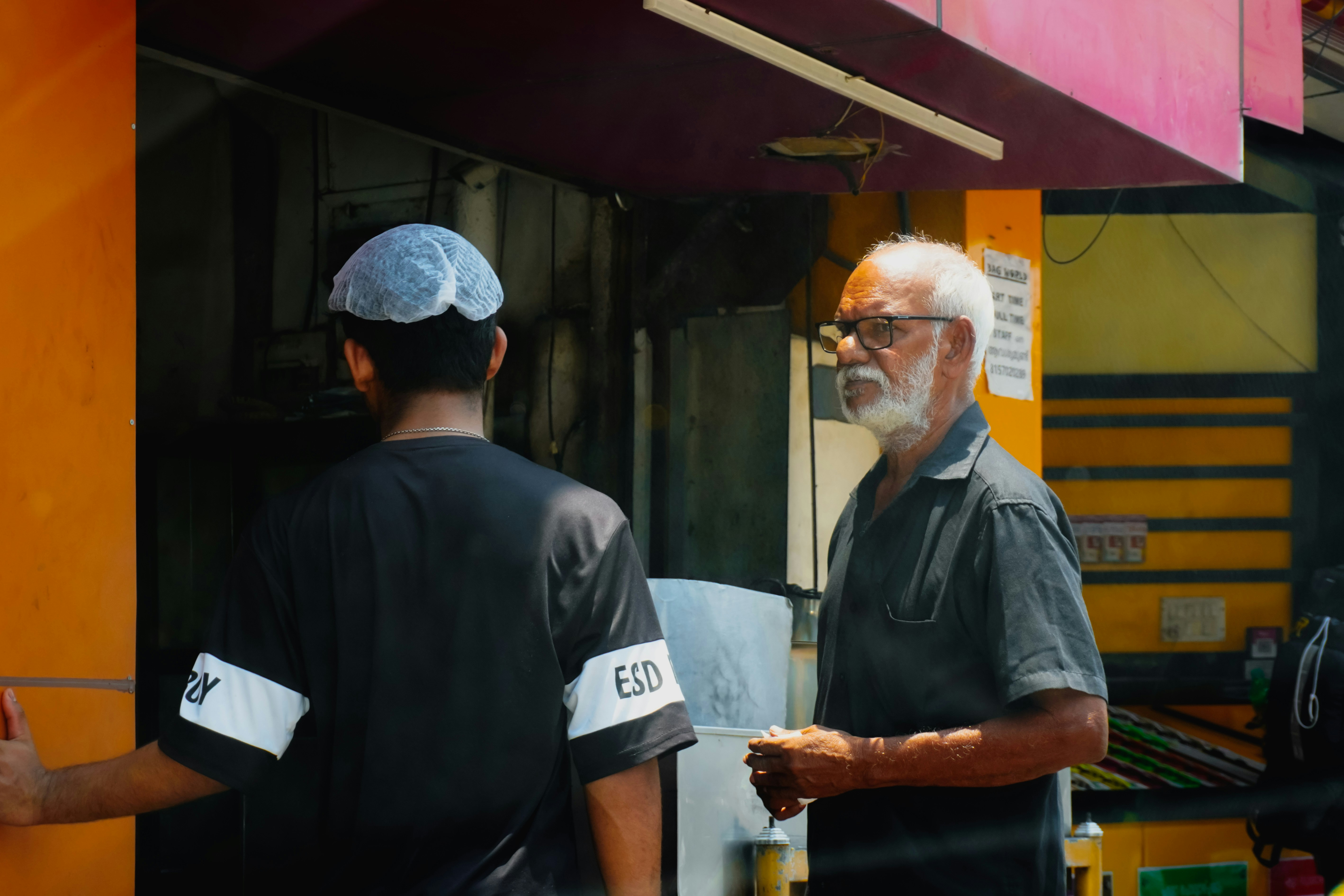 Two Men in a Busy Workshop: A Glimpse of Craft and Conversation