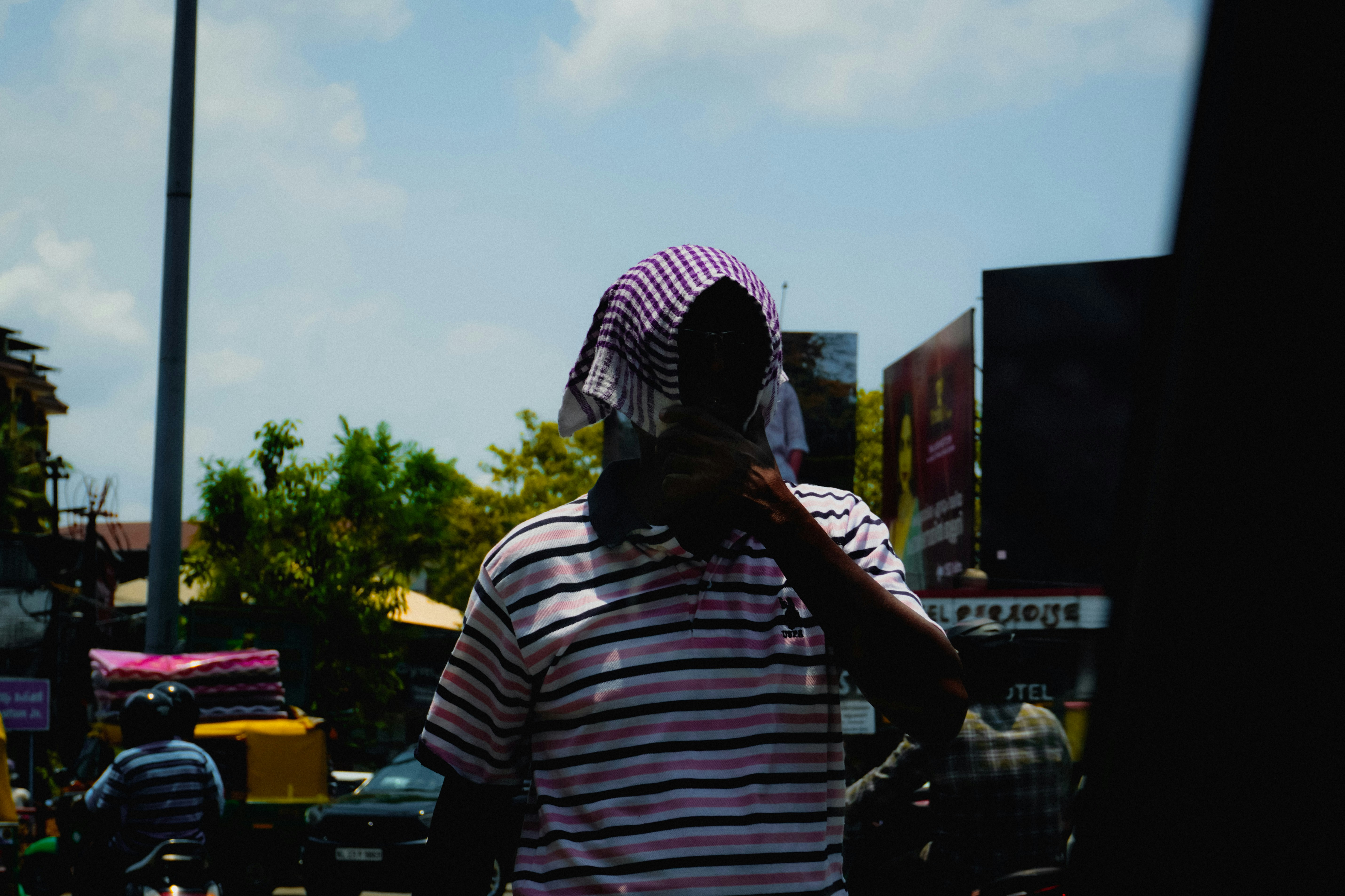 Masked street portrait in shade with striped shirt