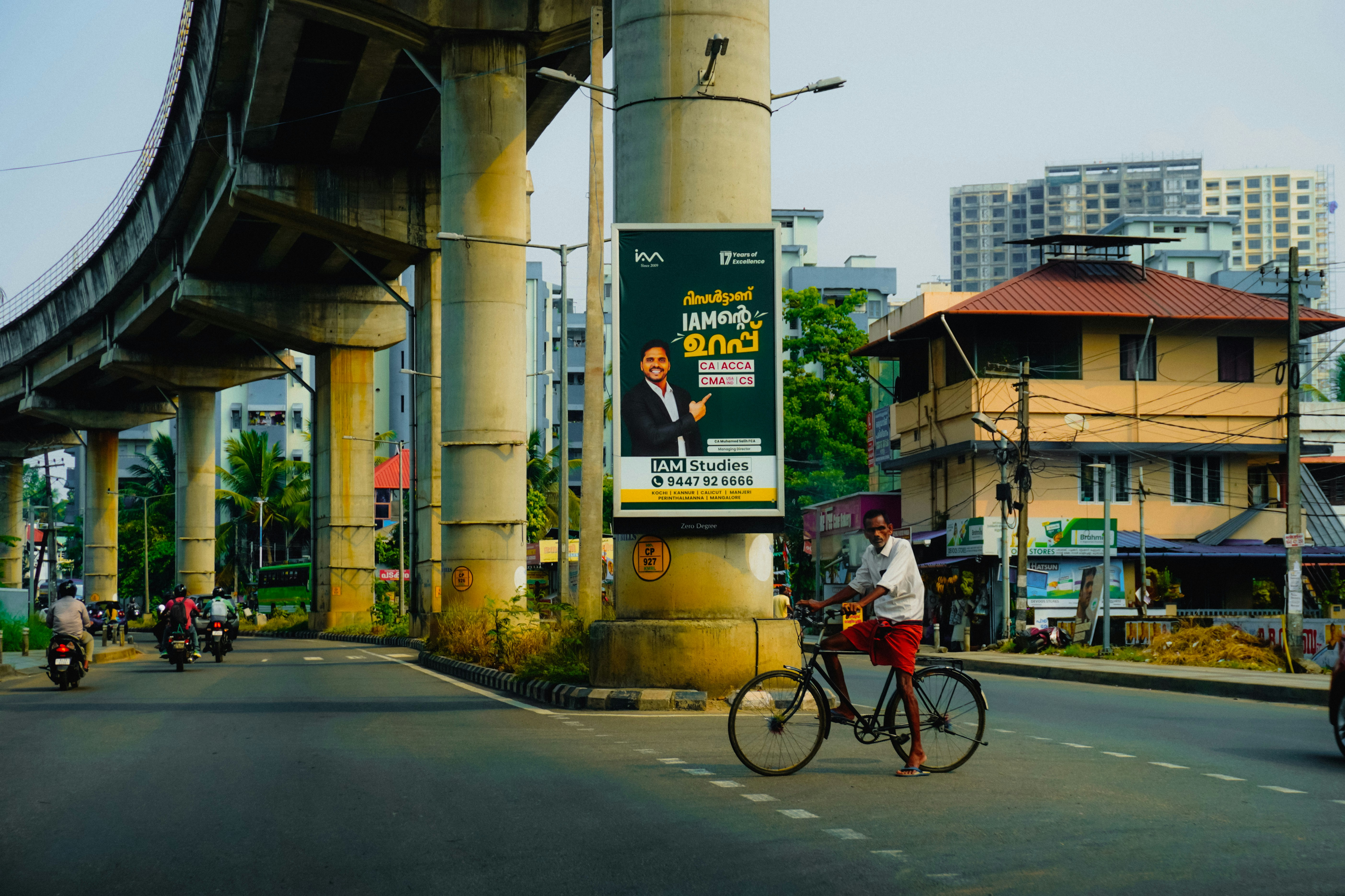 Urban Crossroads: A Cyclist Pauses Under a Concrete Overpass