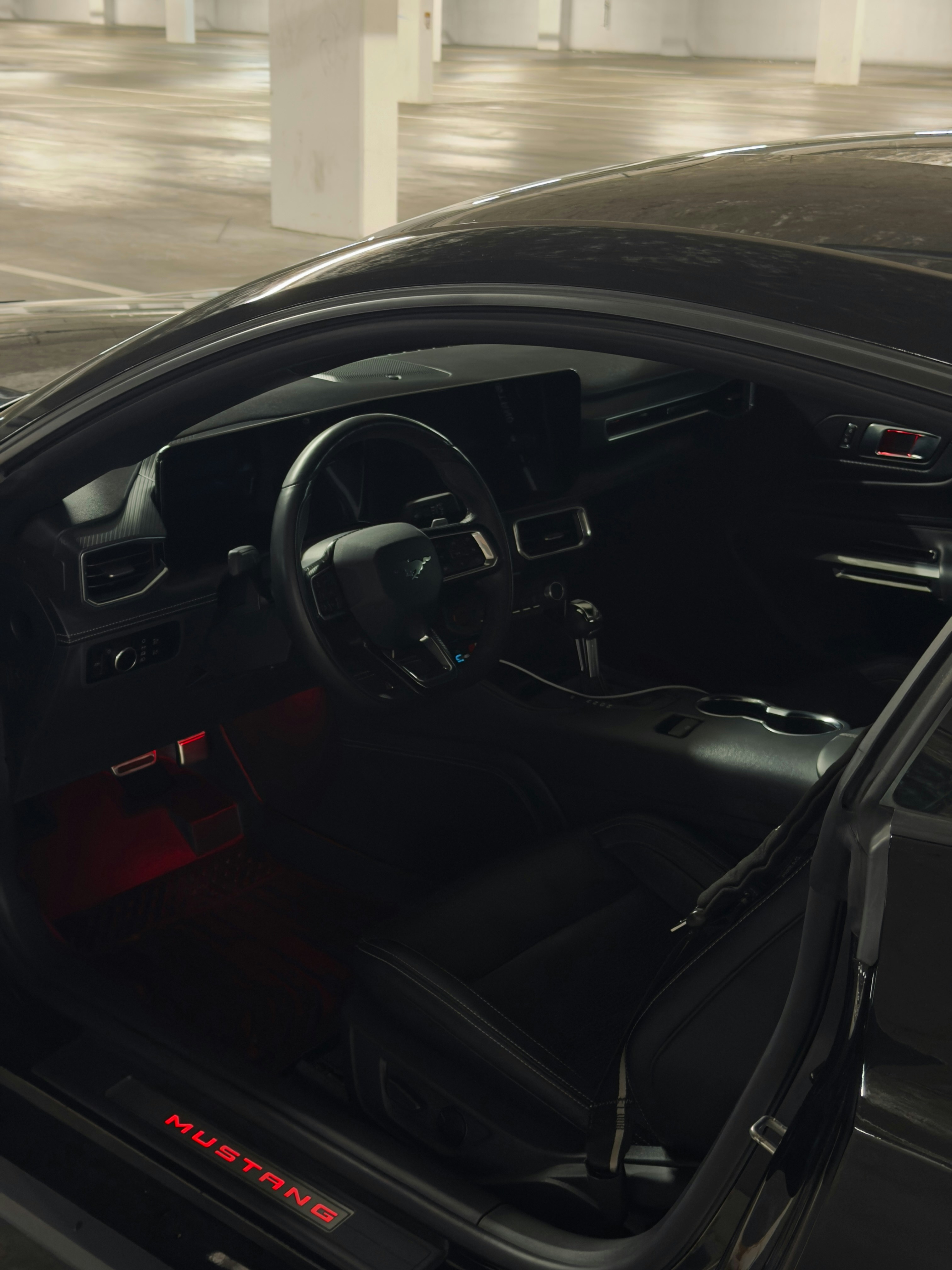 Open Door, Dark Interior: Mustang Cockpit in Dim Parking