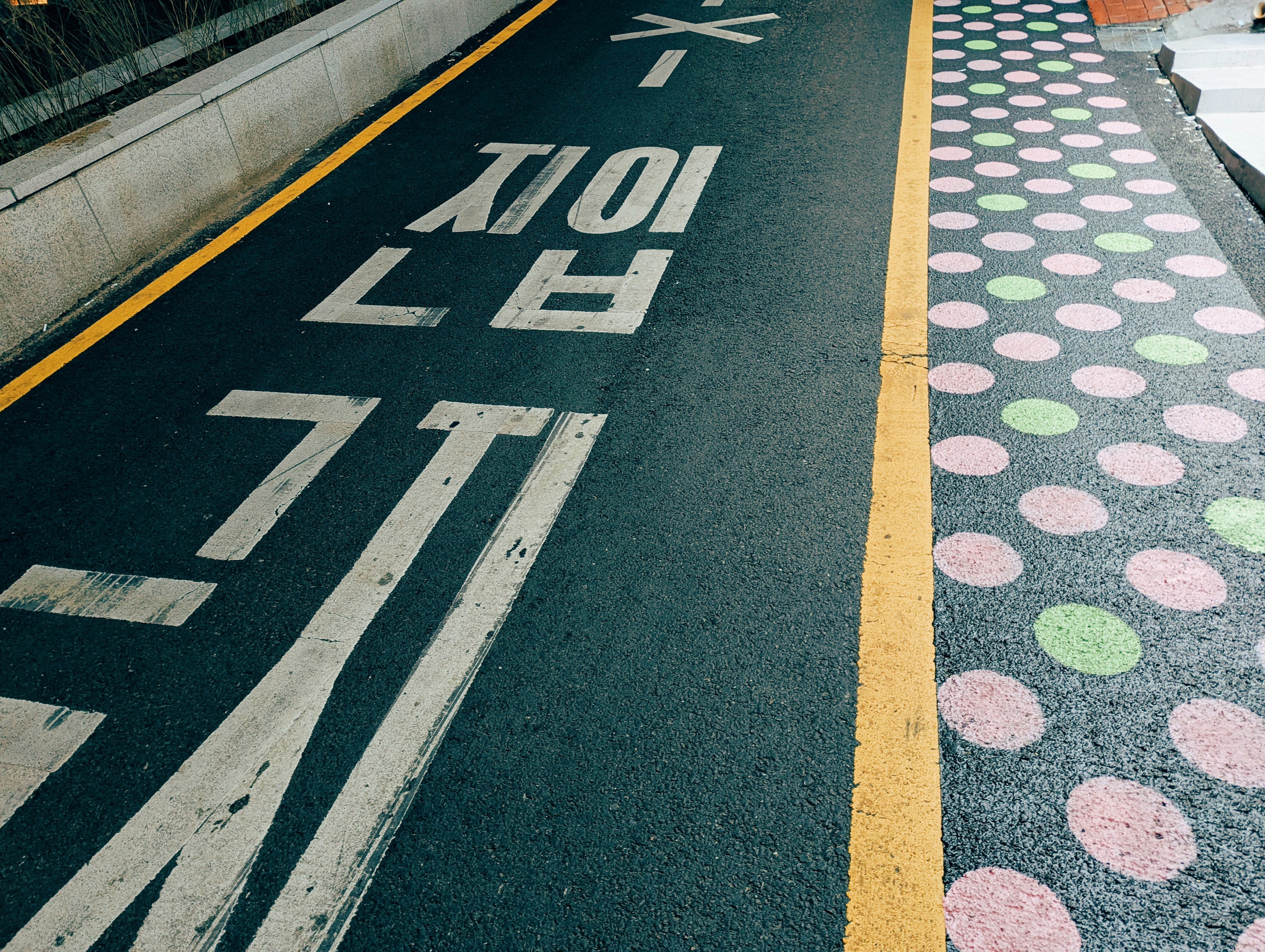 Colorful Urban Road Markings Meet Polka-Dotted Sidewalk