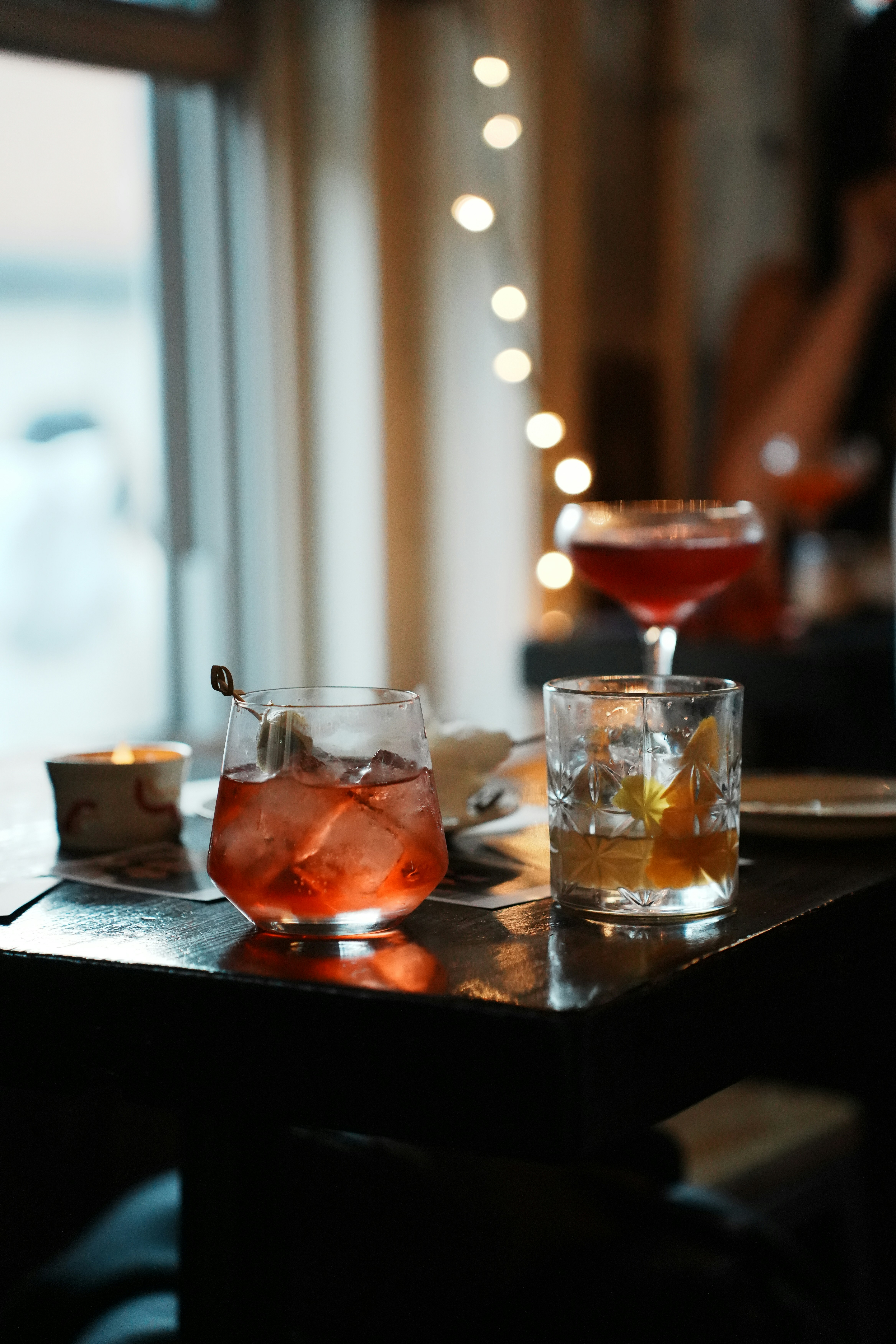 Pierced by Evening Glow: A Trio of Cocktails on a Dimly Lit Table