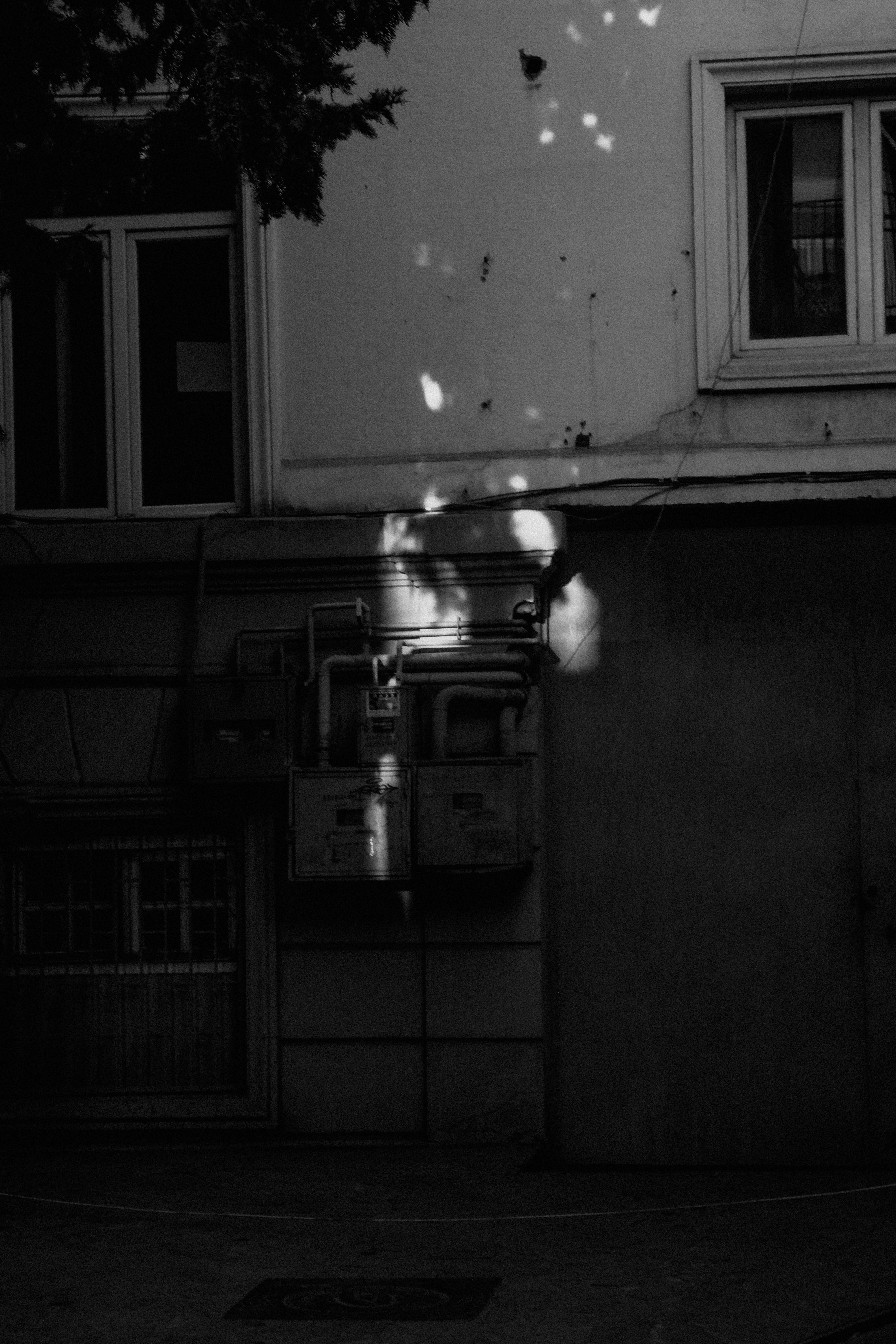Shadowed Utility Facade: Light Dances on a Quiet Wall