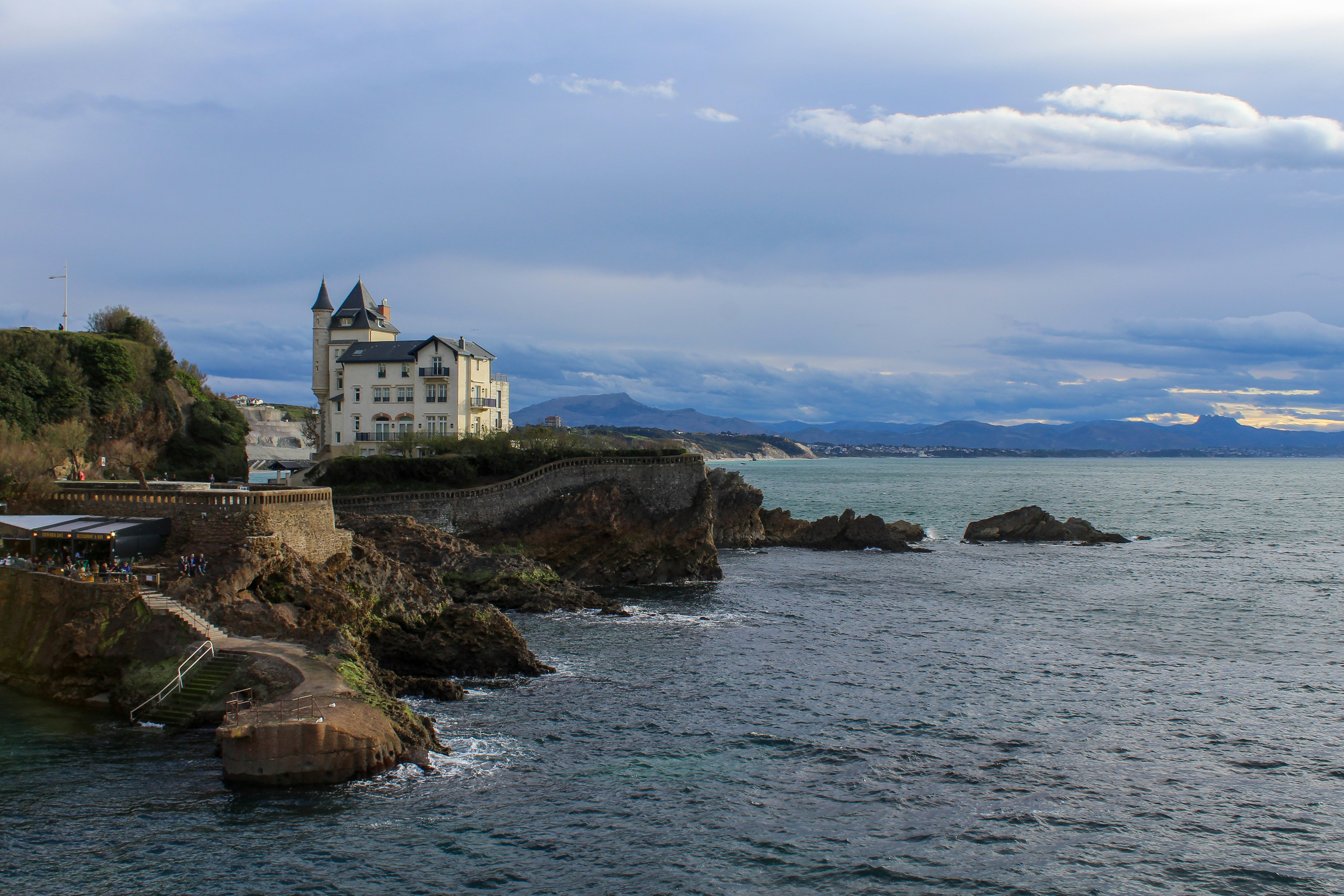 Coastal building on a rocky cliff overlooking the ocean.