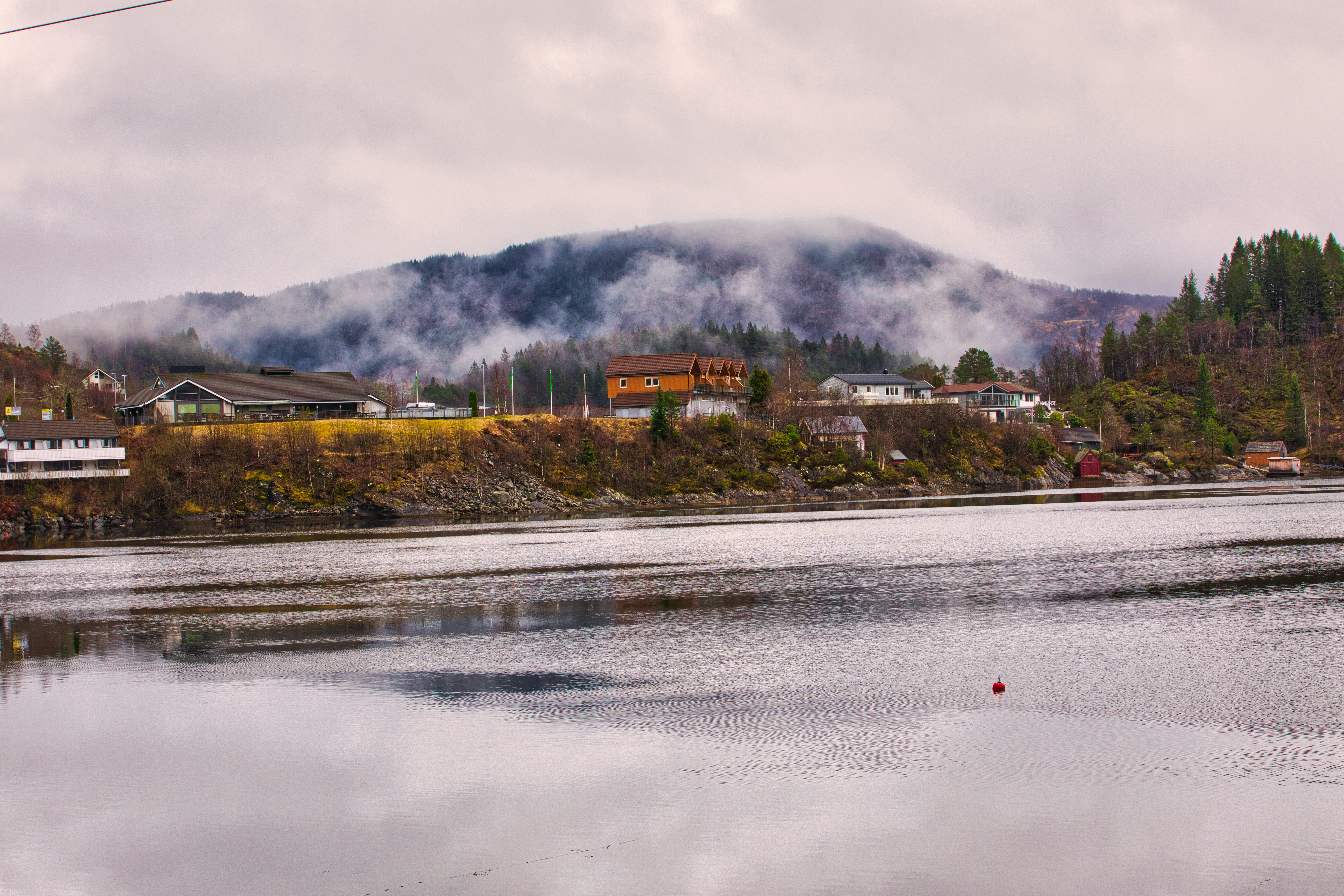 Quiet lakeside village under misty mountains
