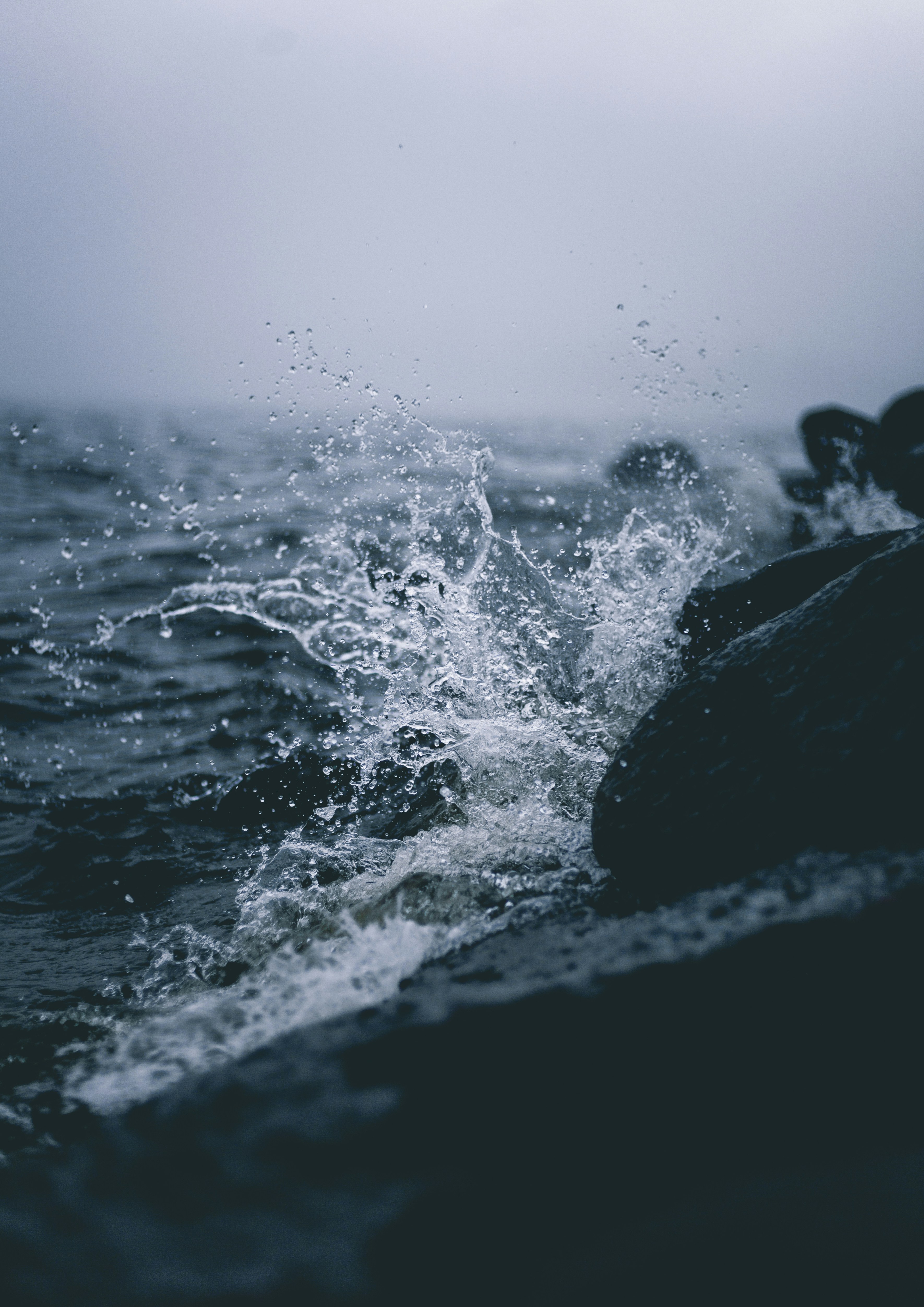 Wave Collision against Cold Rock: A Quiet Ocean Spray