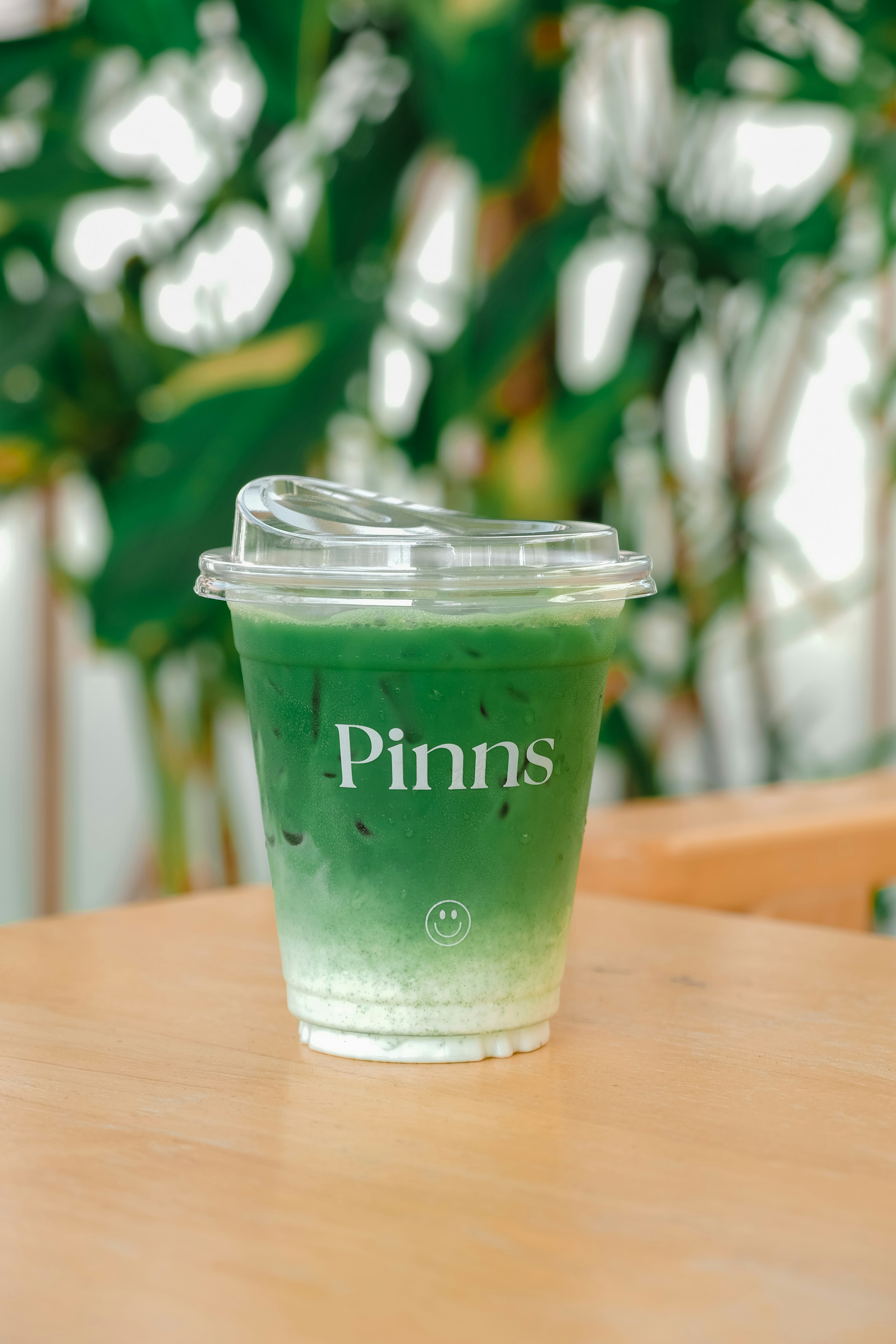 Green Gradient Latte in Focus at a Sunlit Café