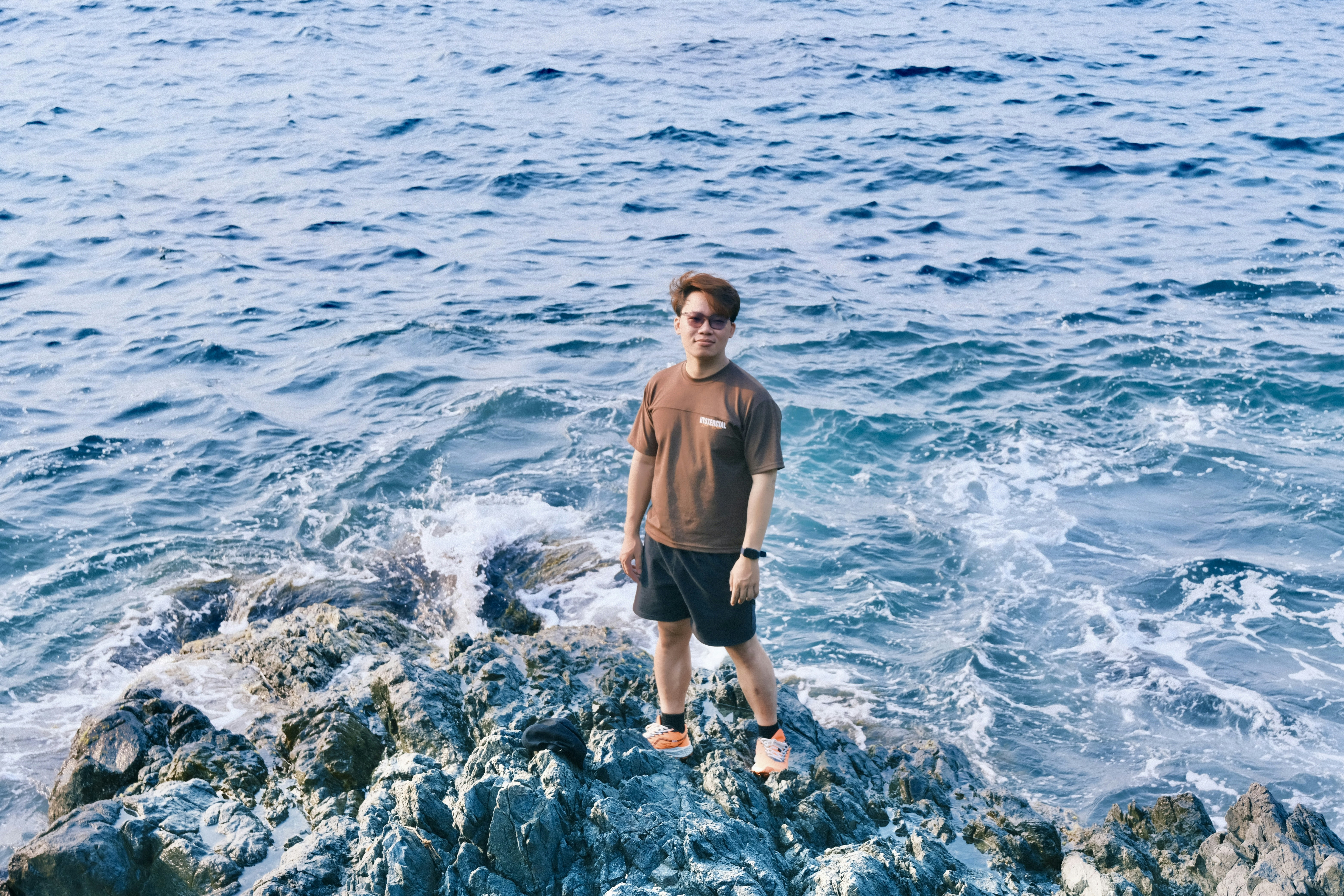 Rugged Resolve: A lone climber stands on jagged shoreline
