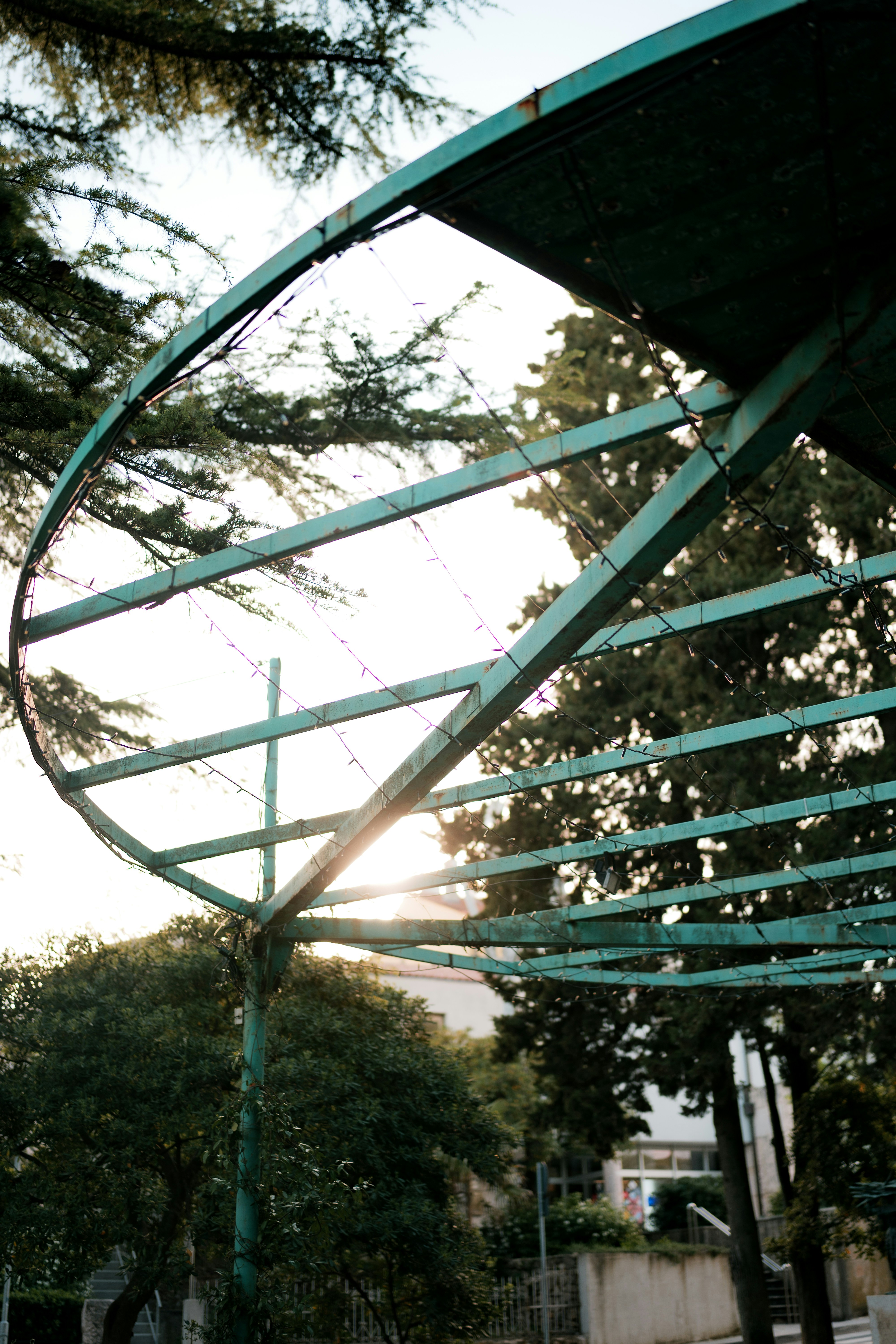 Sunlit Structure: Green Steel Arches Framing a Quiet Morning